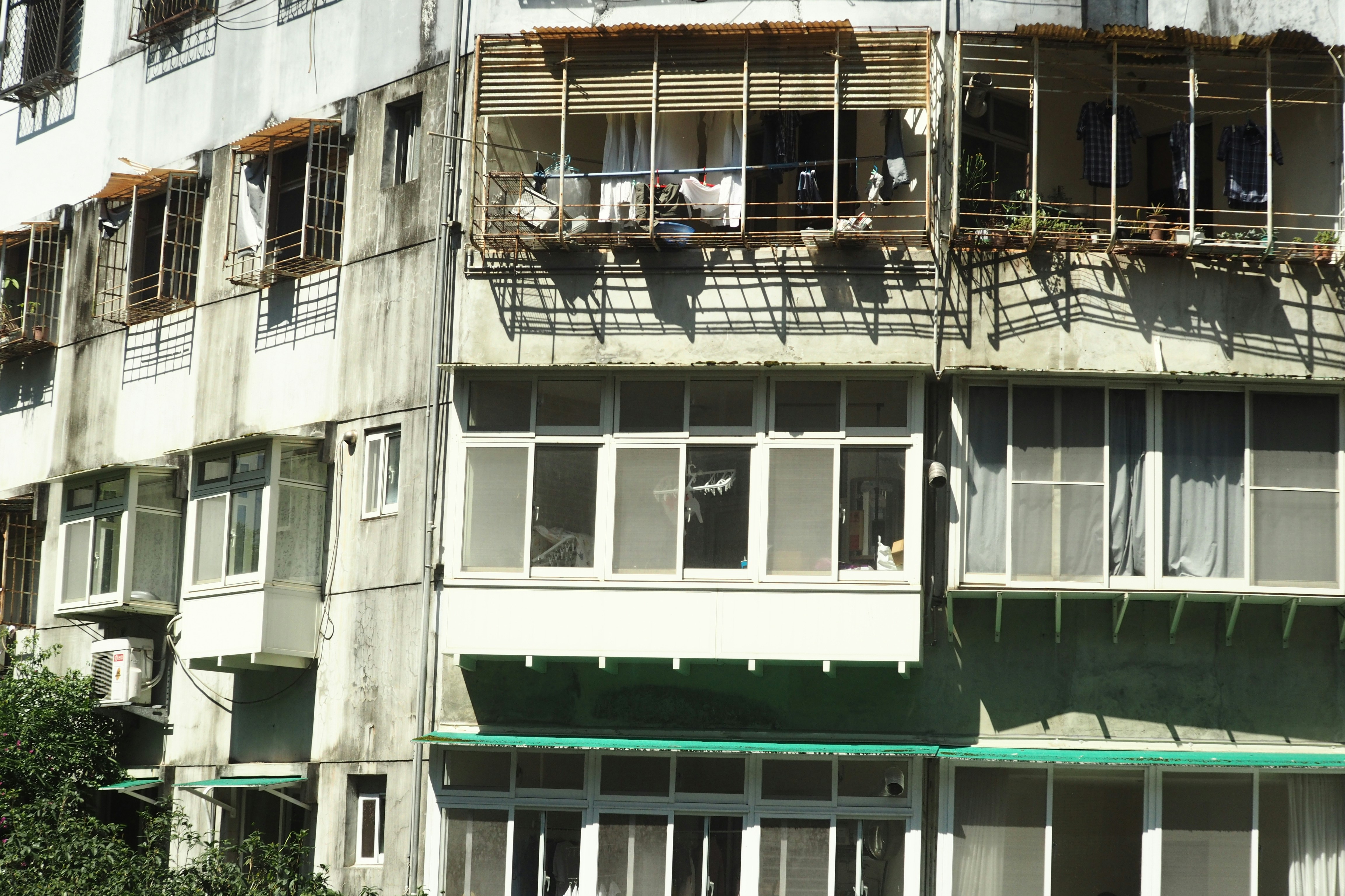 Weathered concrete windows: a sun-soaked facade with laundry and balconies
