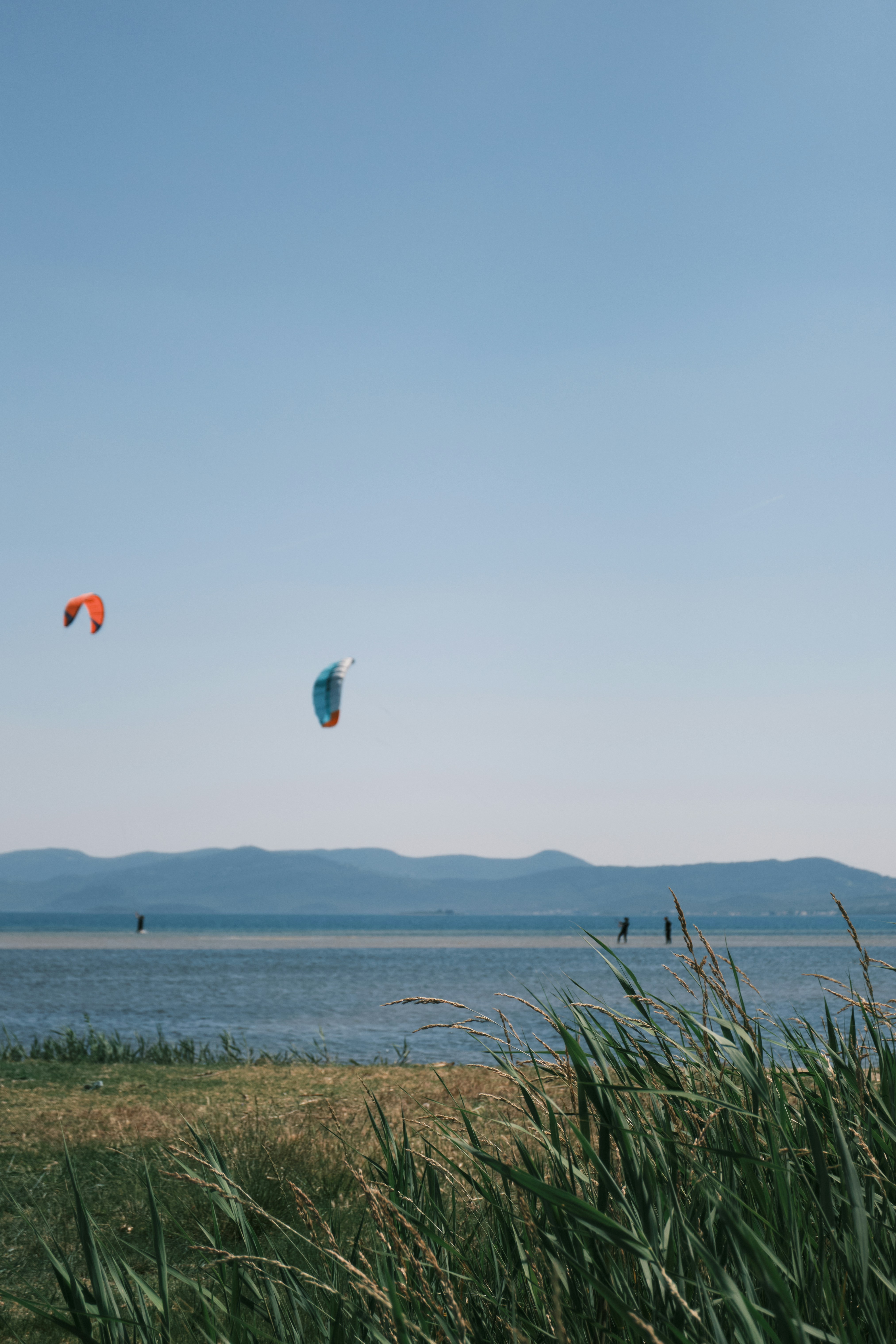 Kite Surfers Across a Quiet Coastal Horizon