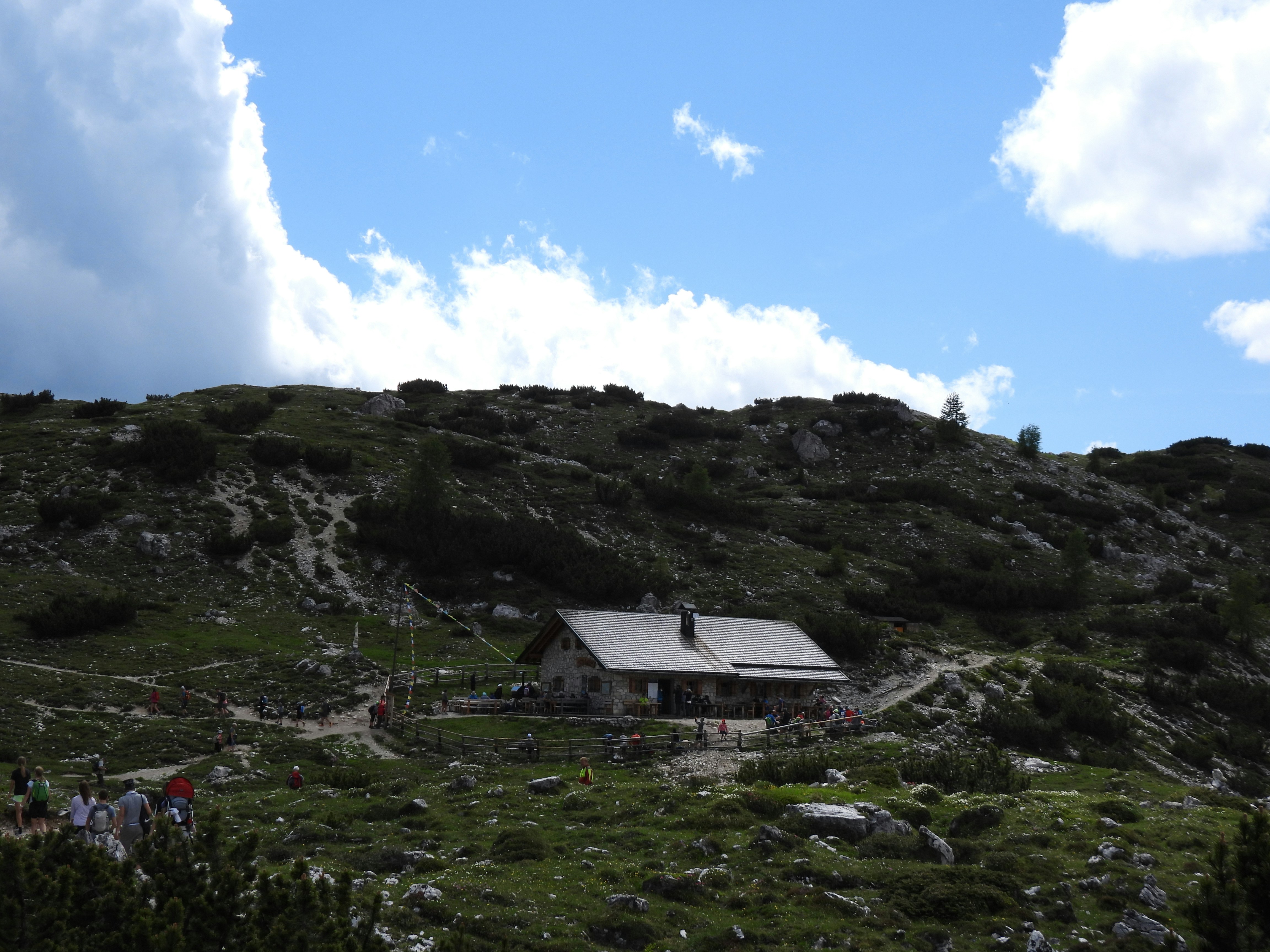 Cordillera Refuge: A Stone Cabin Amid Green Slopes under a Blue Sky