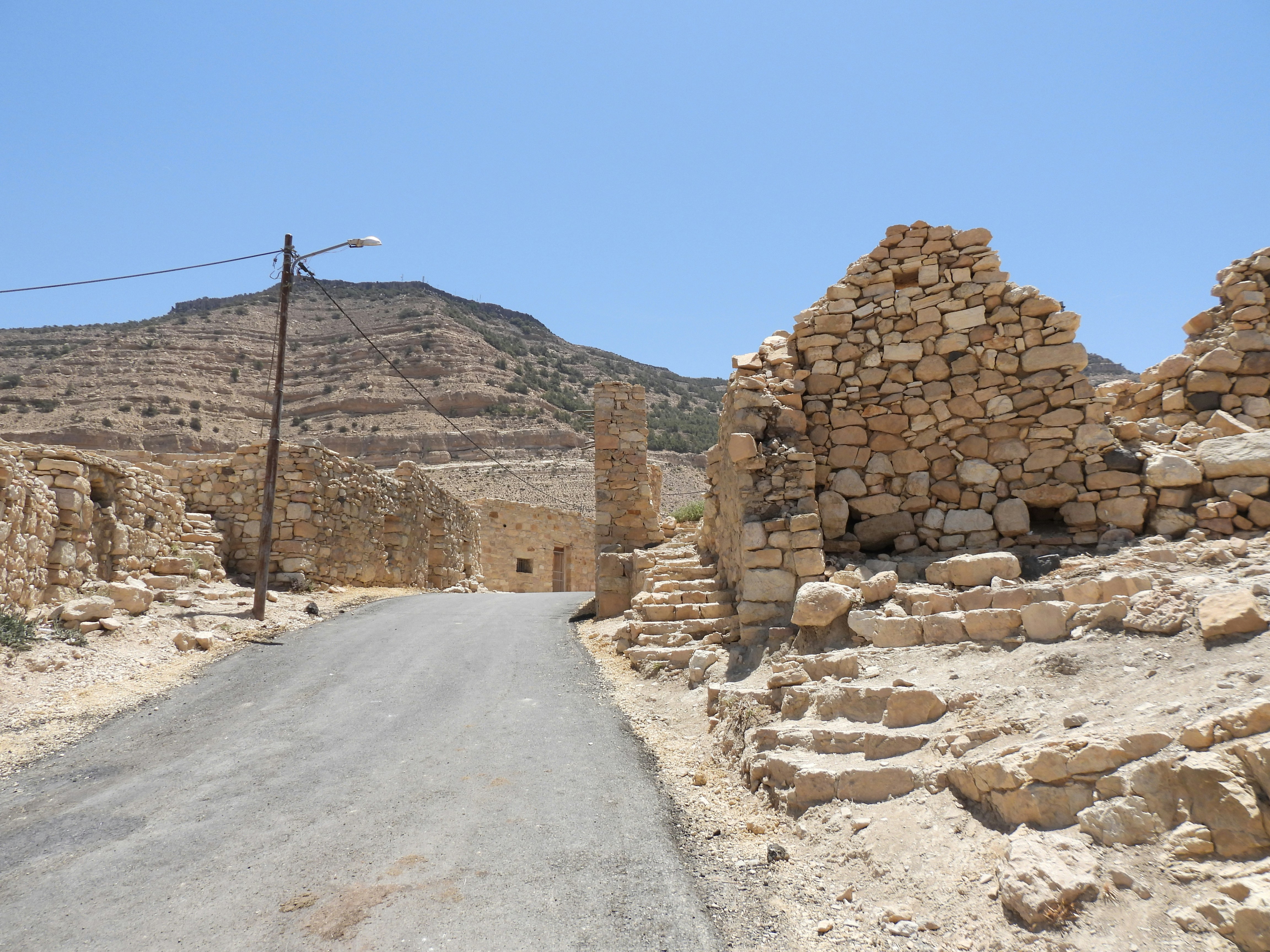 Deserted Road Through Stone Ruins Beneath a Clear Sky