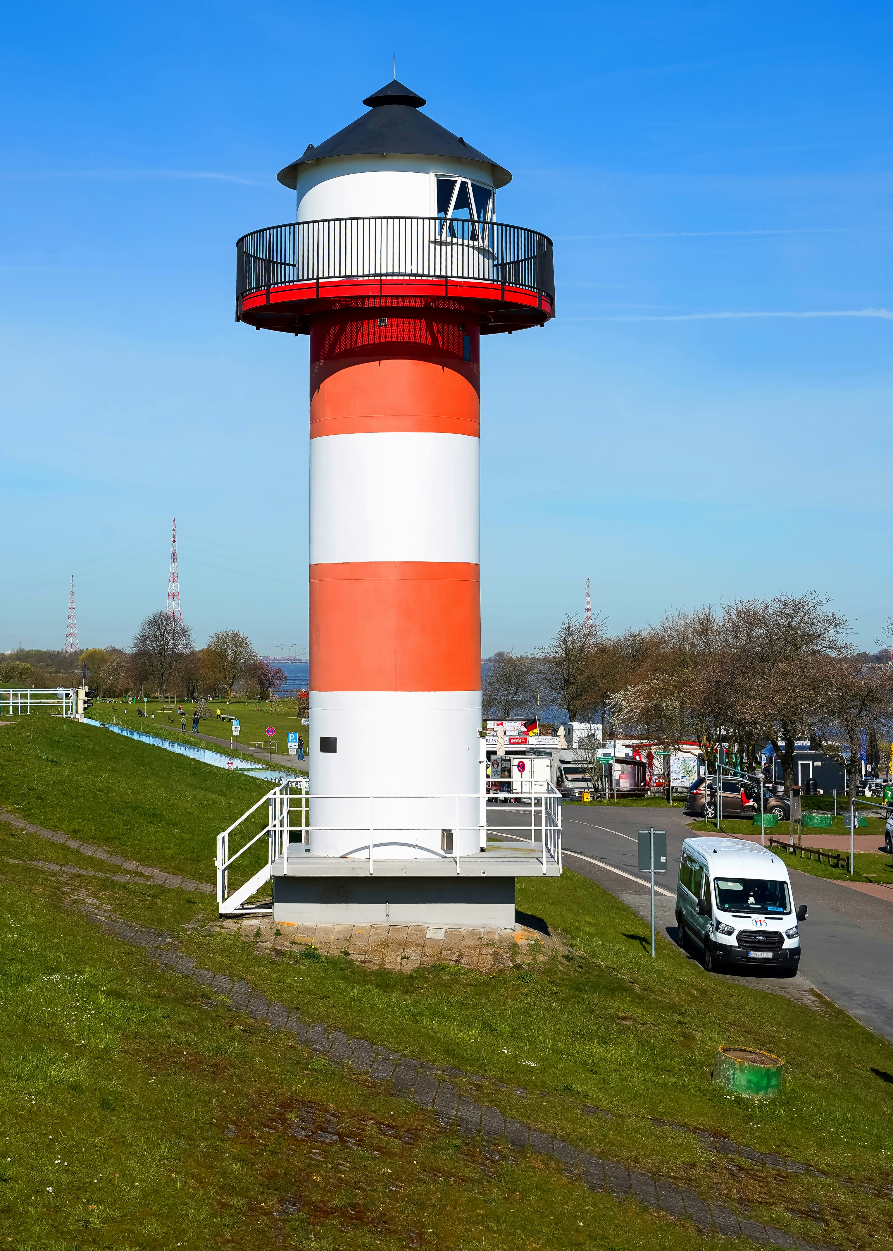 Lighthouse on a Green Ridge Under a Bright Blue Sky