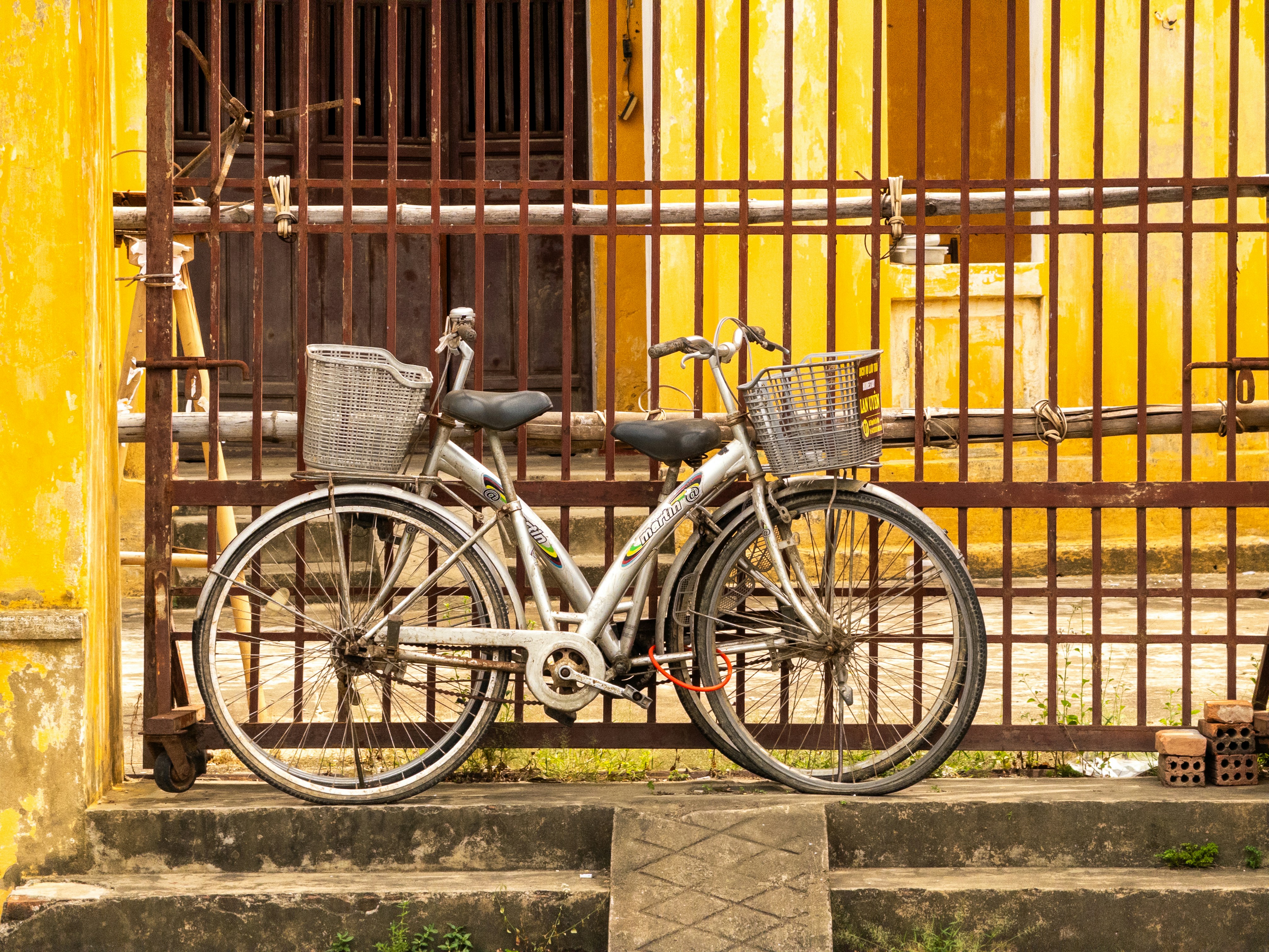 Two-wheeled harmony against a sunlit yellow gate