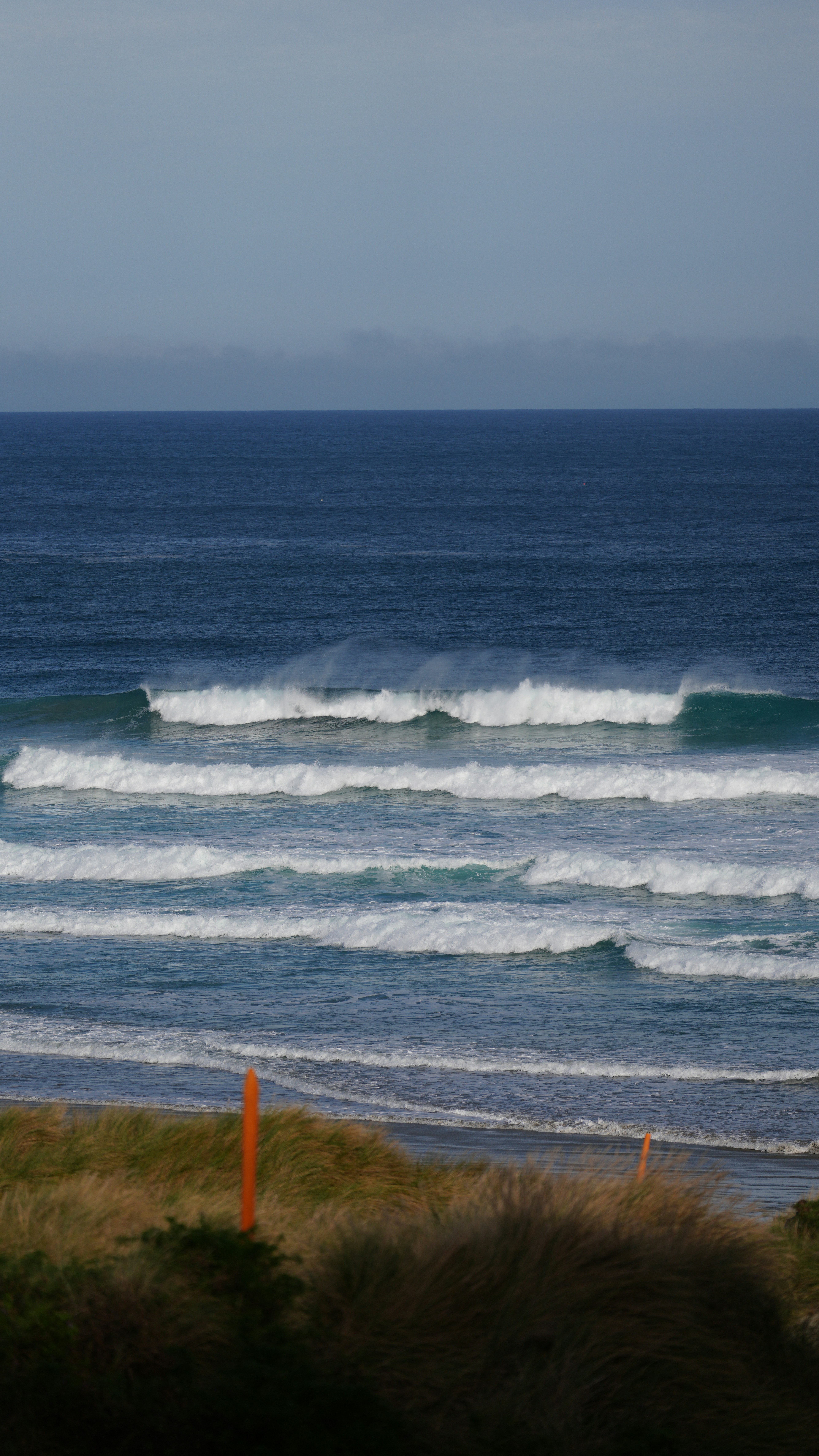 Low Tide of Quiet Dunes: Ocean Waves Rolling in a Calm Horizon