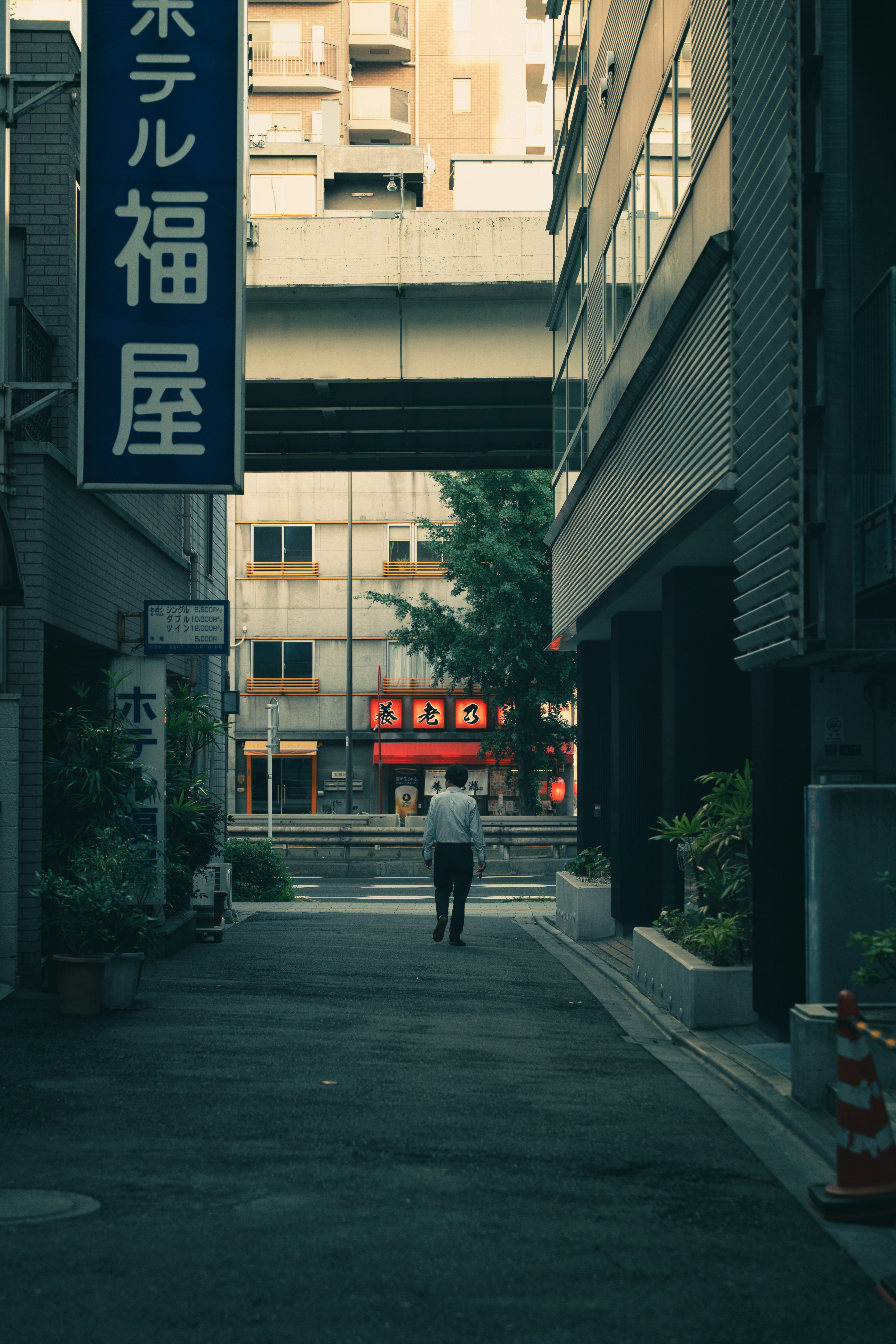 Man walking away in a narrow urban alley.