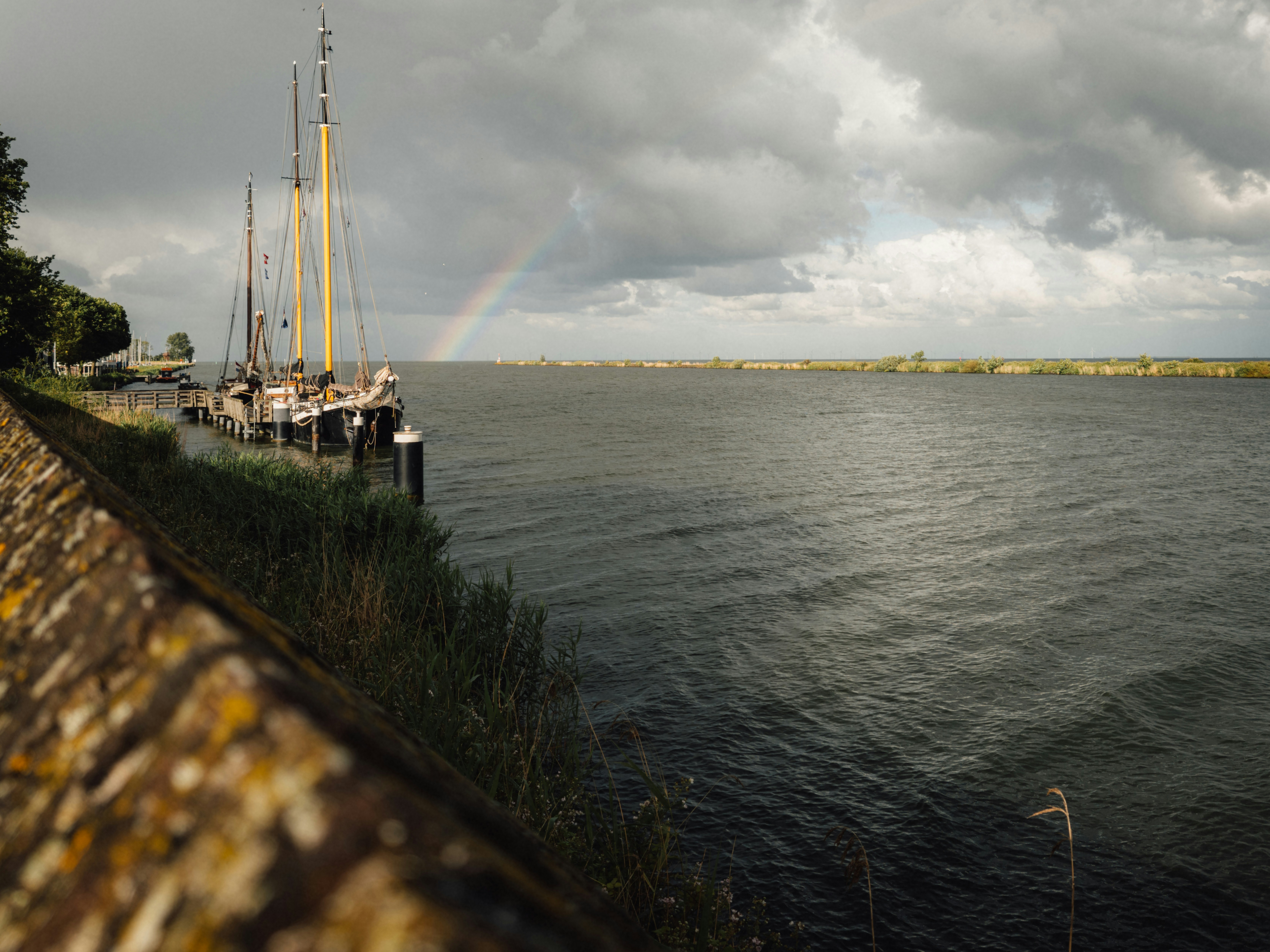 Rainbow Over the Pier: Boats, Water, and Clouds