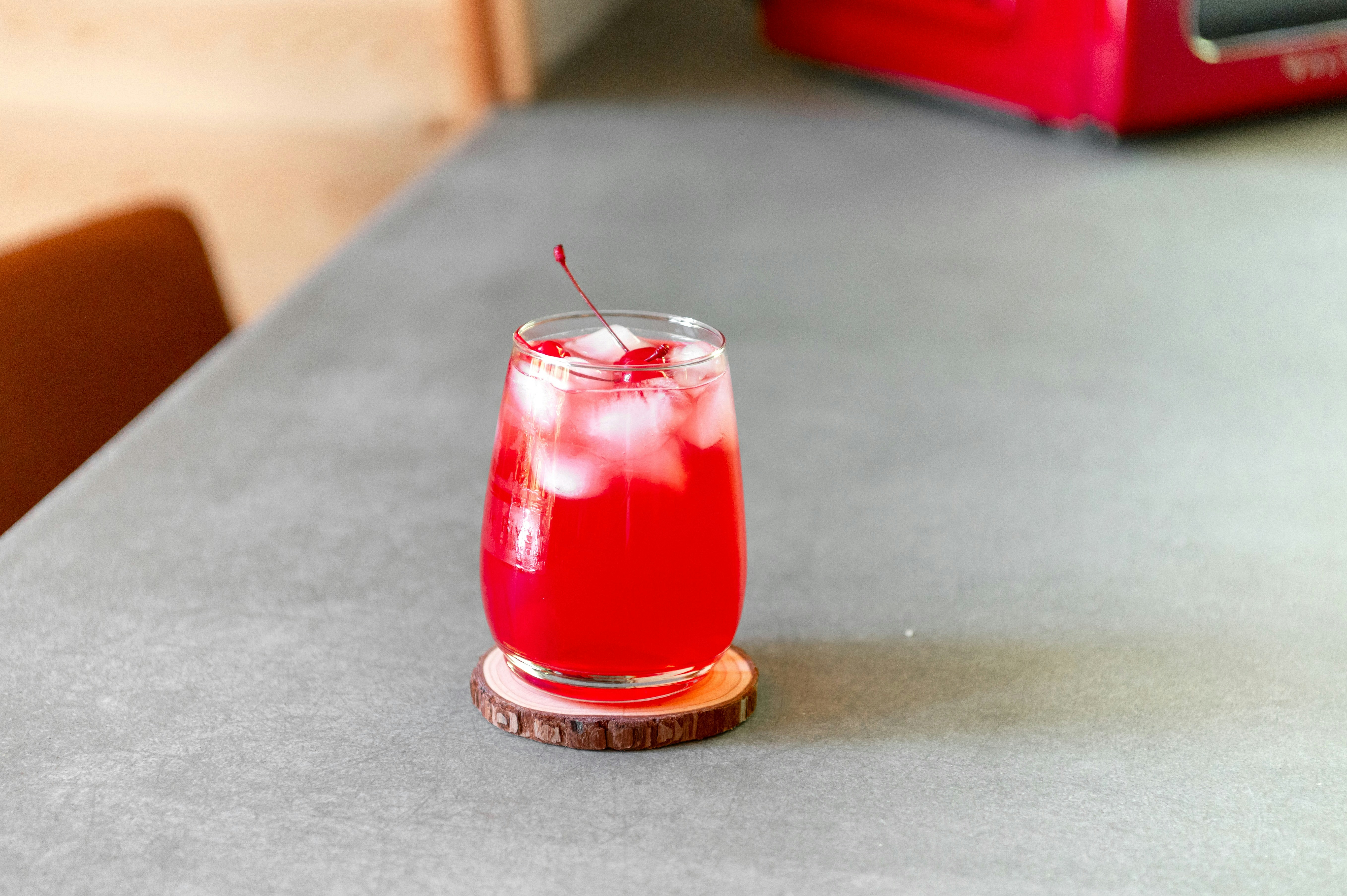 Crimson Cocktail on a Wooden Coaster