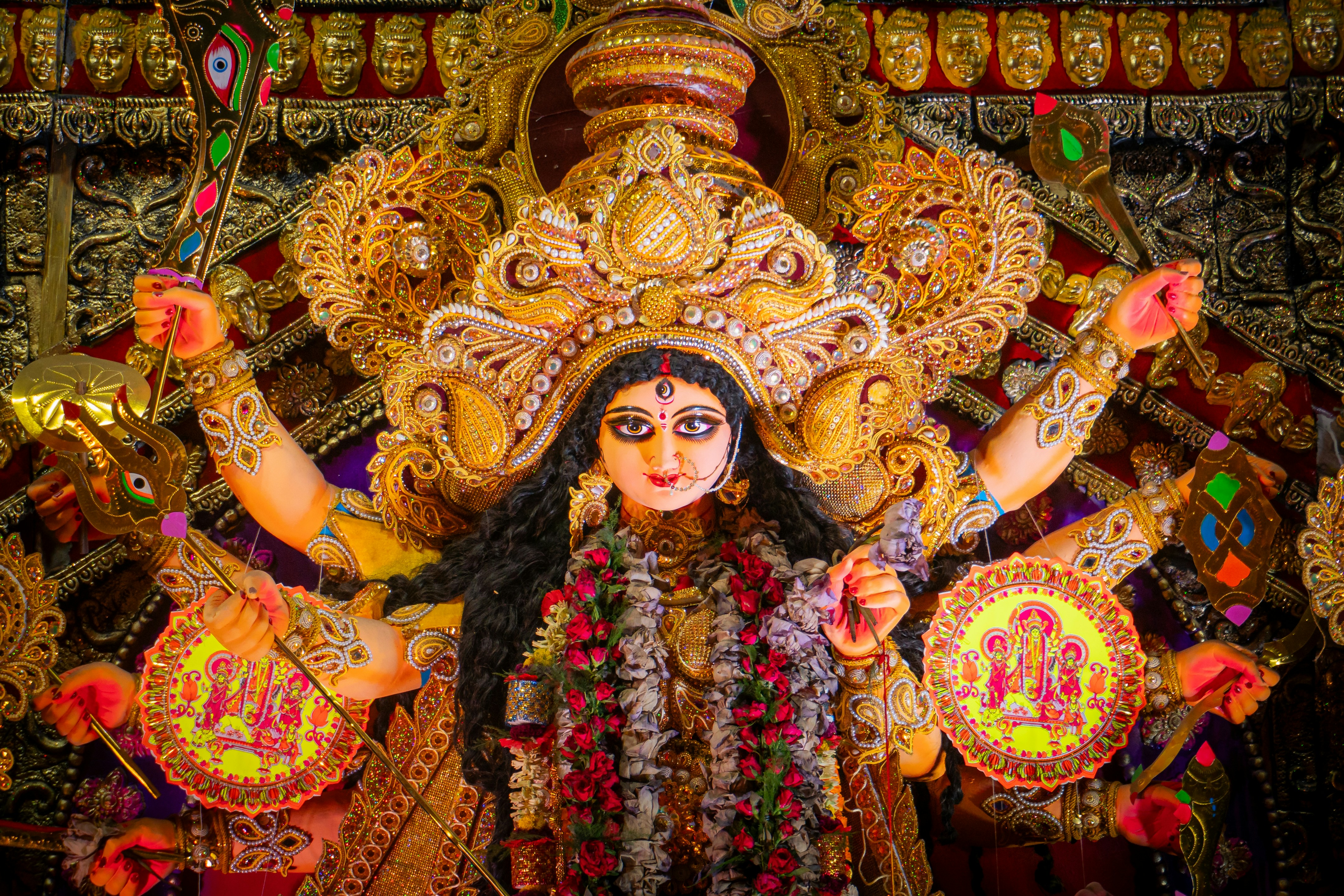 Elaborately decorated statue of hindu goddess durga with multiple arms.