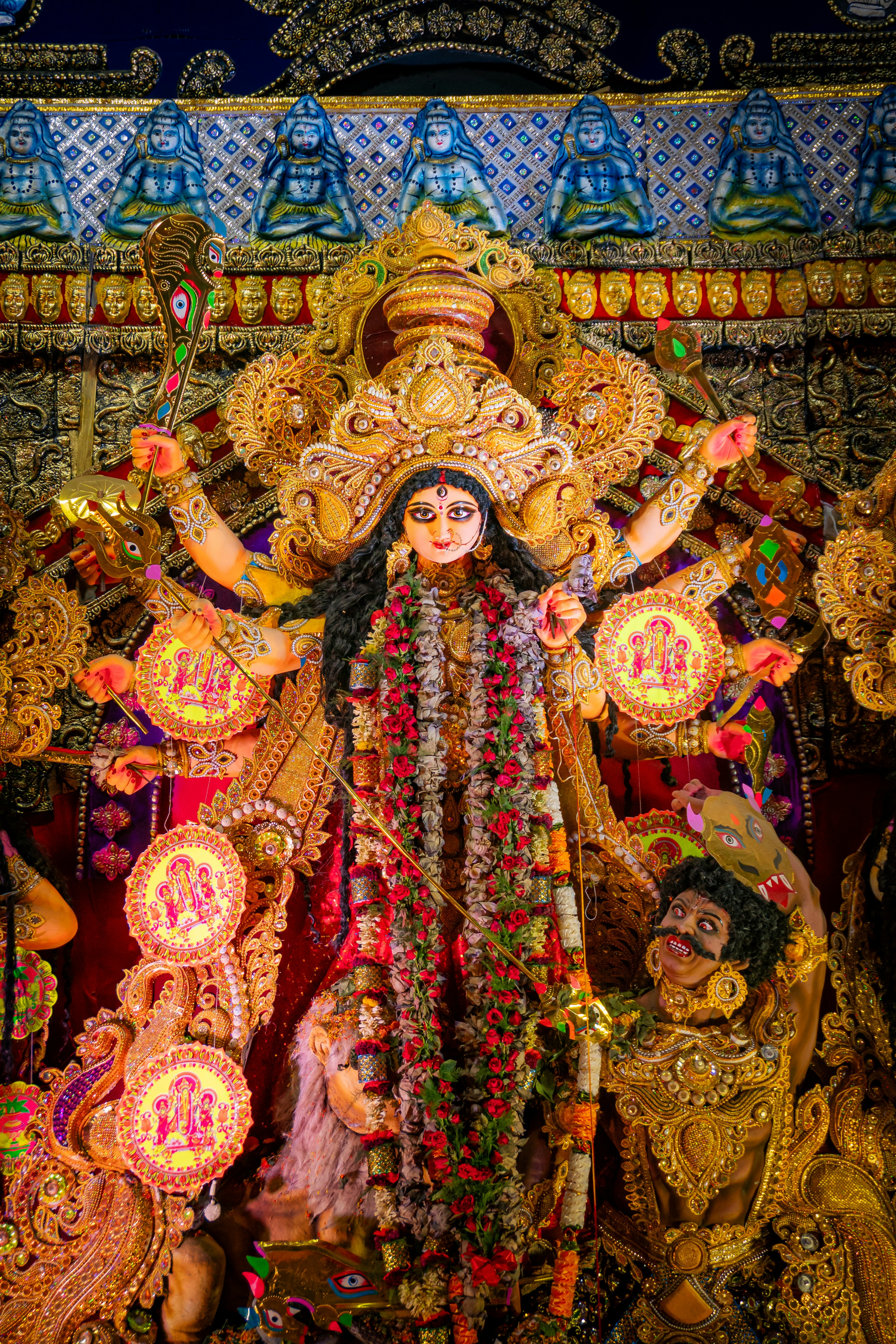 An elaborate idol of hindu goddess durga adorned with garlands.