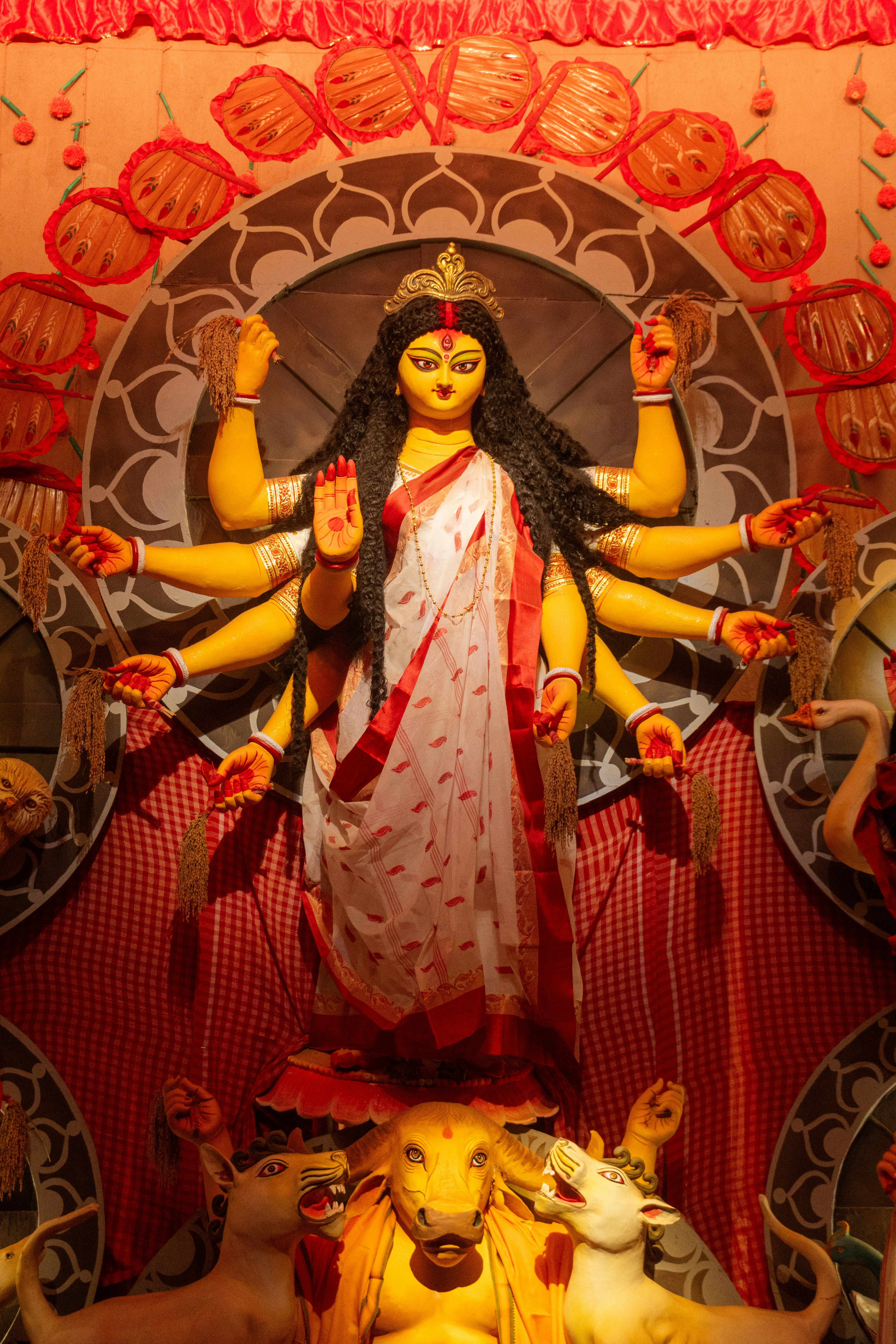 A multi-armed hindu goddess statue adorned with decorations.
