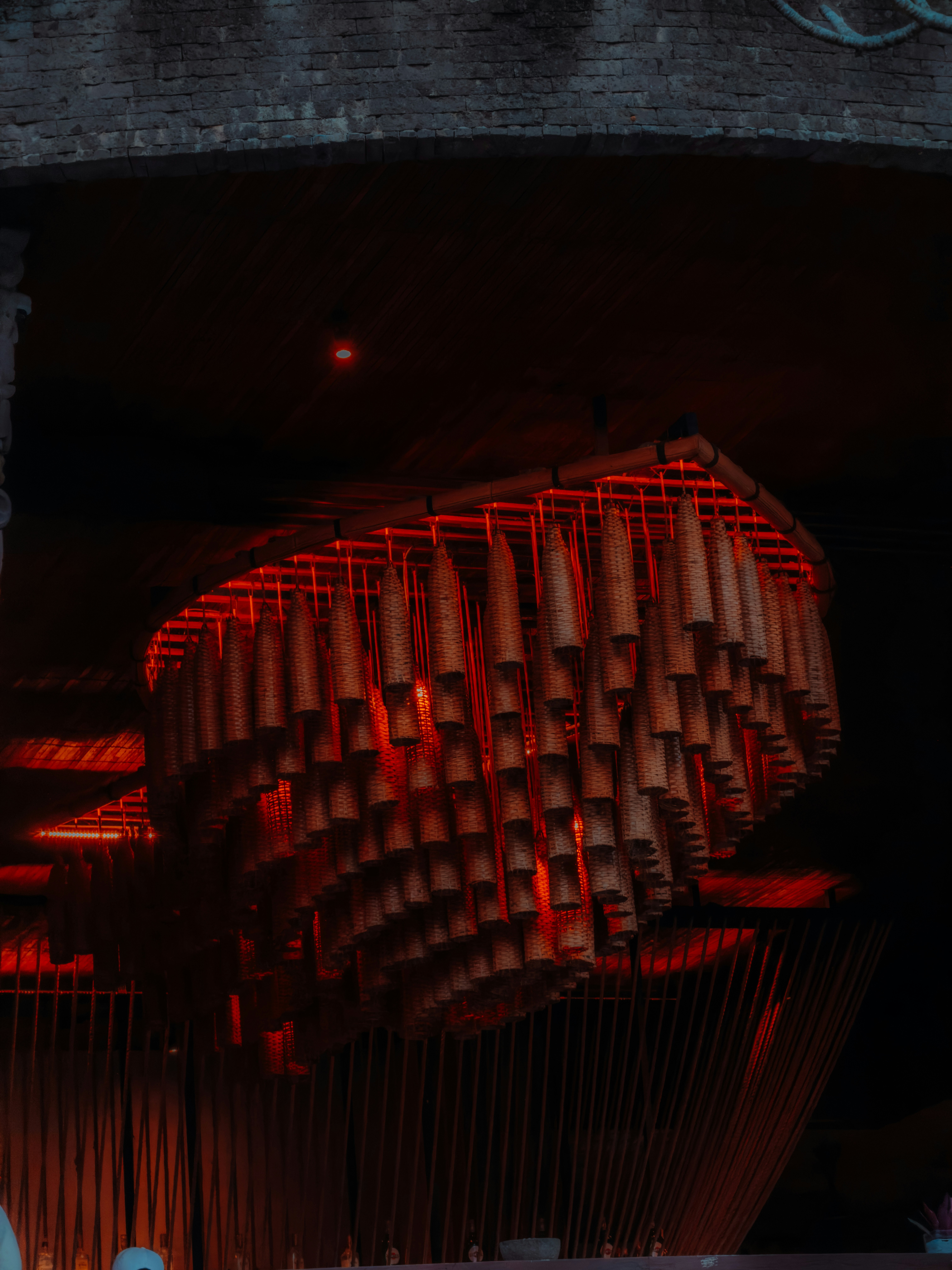 Red-Tinted Chimes: A Dimly Lit Ceiling Fixture in a Night Scene