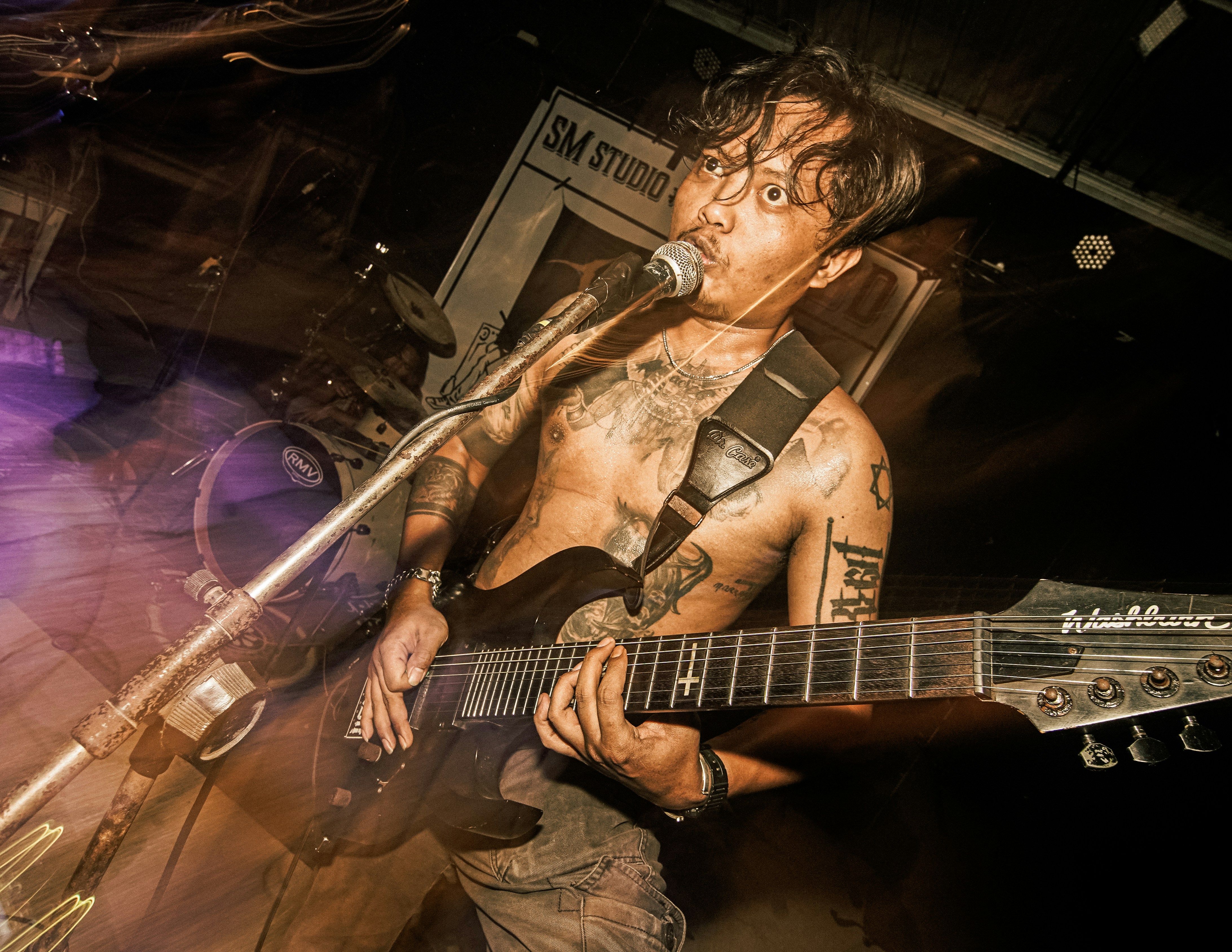 Neon strings: guitarist vocals in a sultry, dim-stage blaze