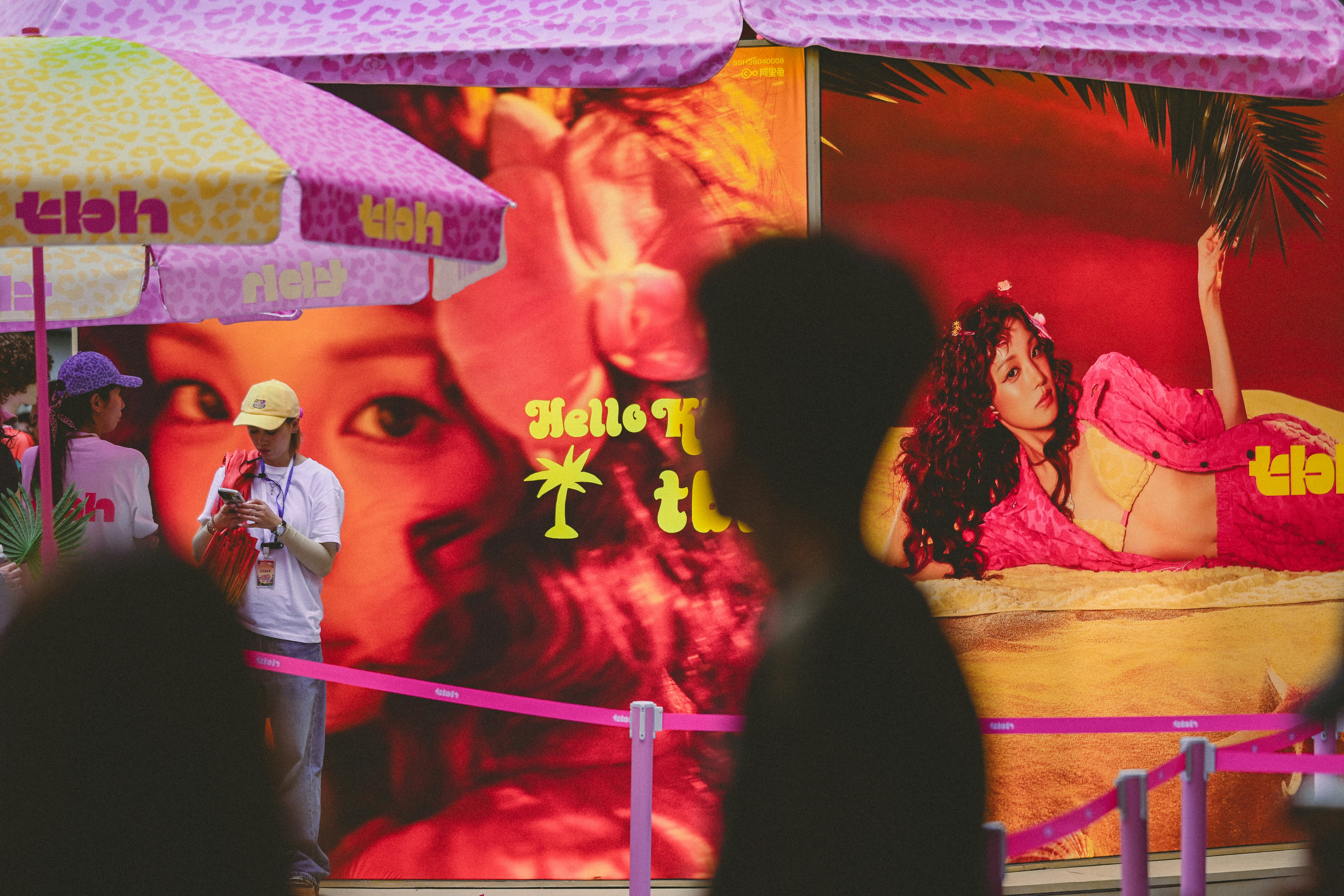 Attendees view a large billboard with a woman and umbrellas.