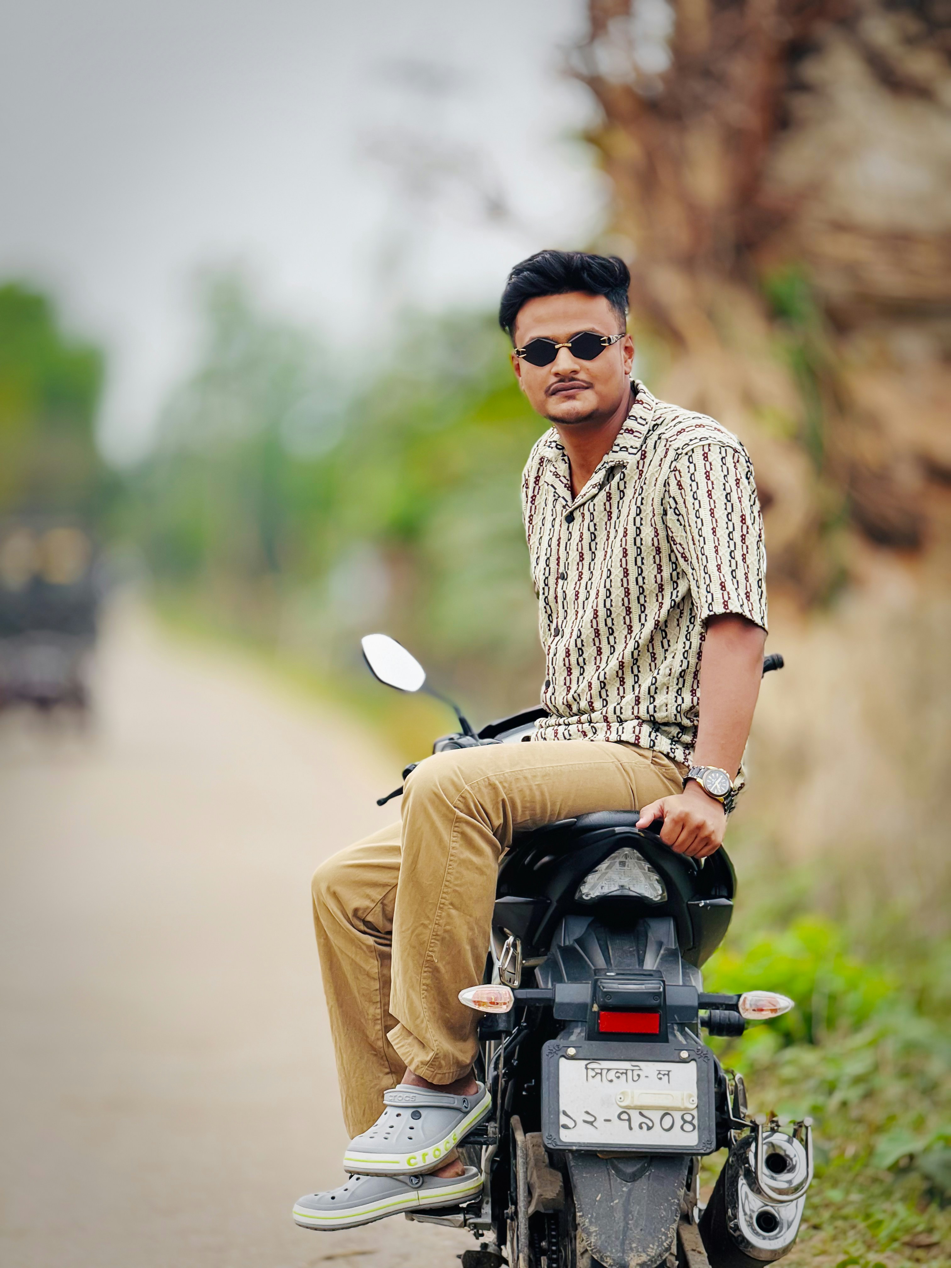 Man in sunglasses sitting on a motorcycle outdoors.