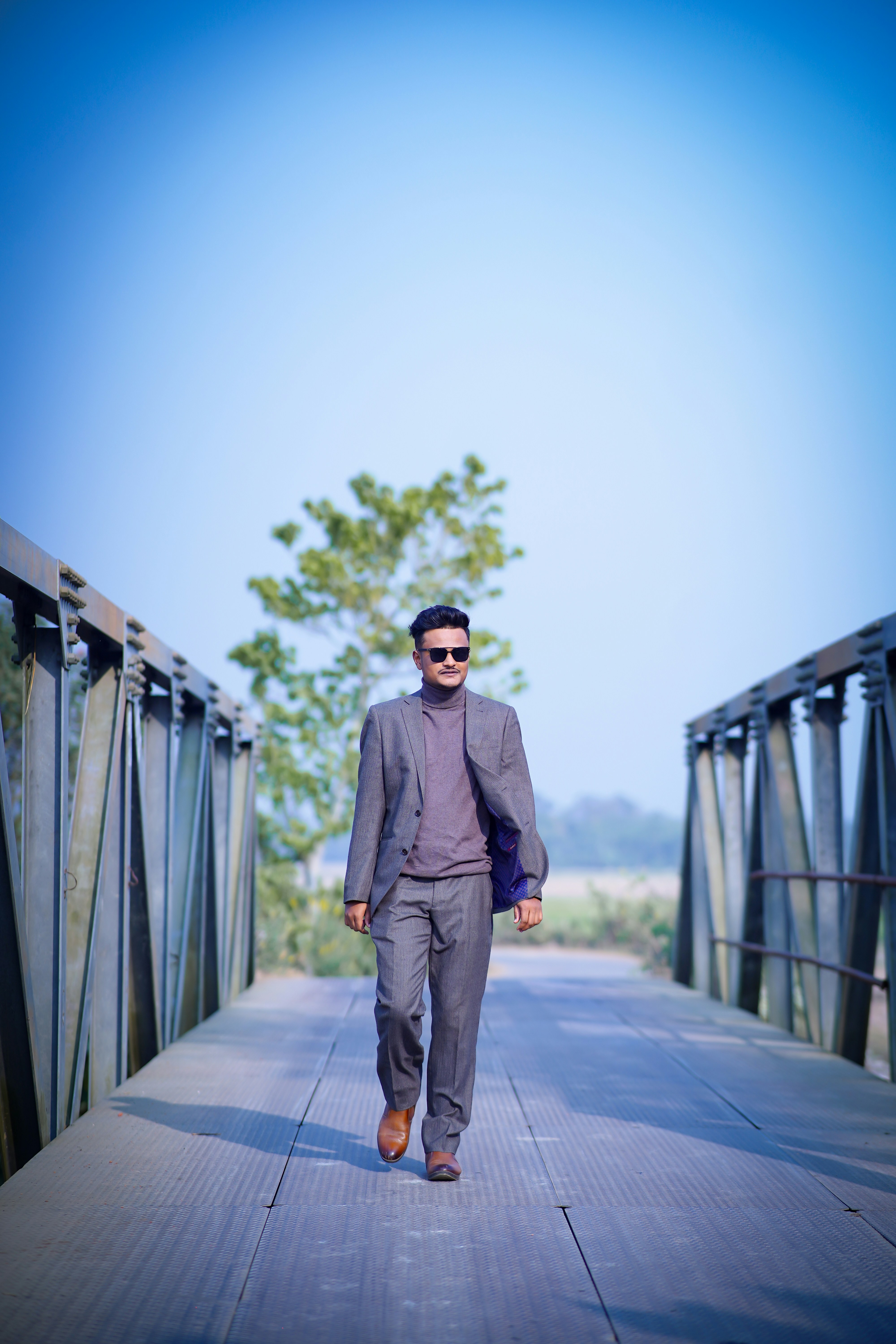 Man in a Sharp Gray Suit Walks a Quiet Bridge