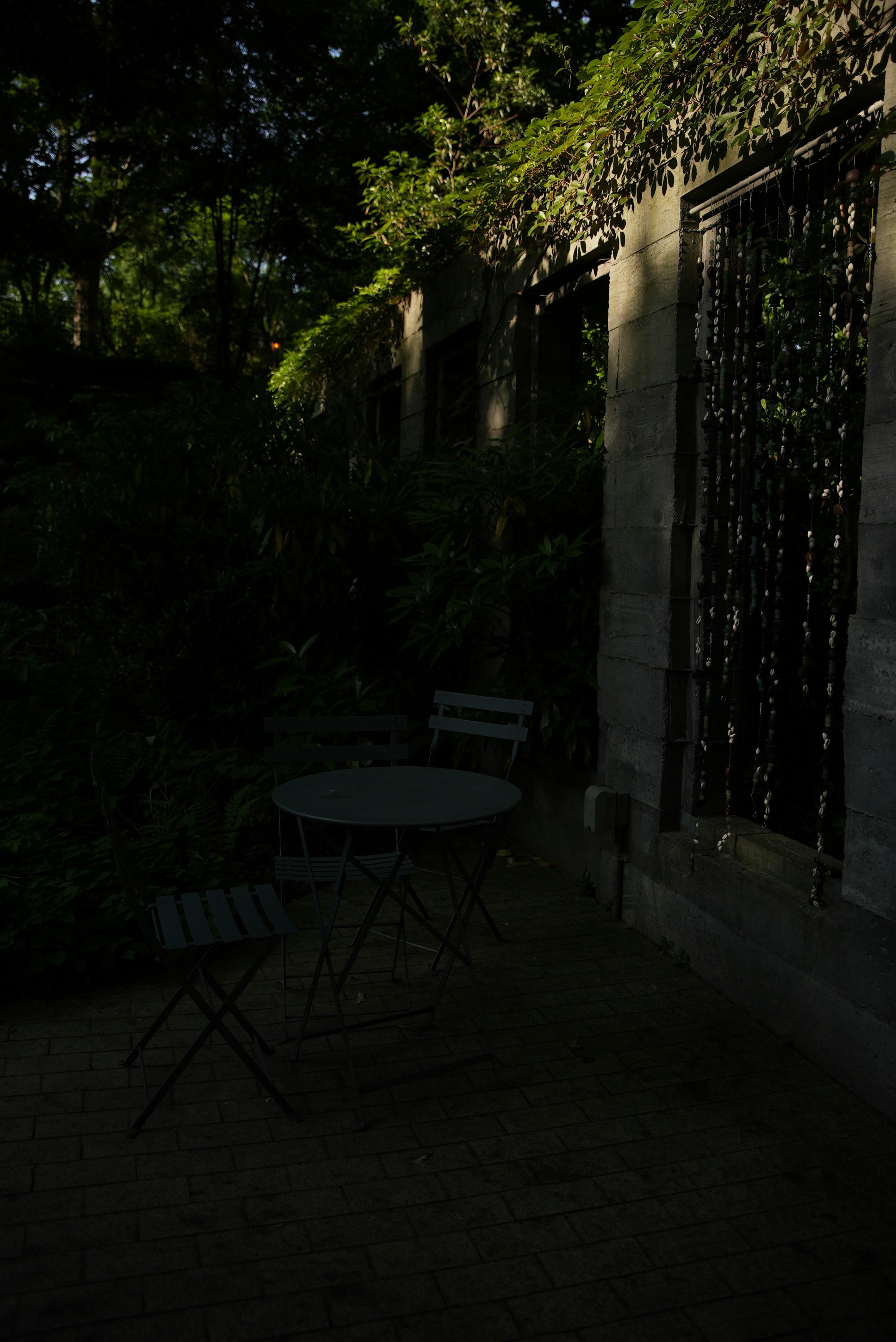 Quiet Patio After Sunset: A Dimly Lit Courtyard with a Metal Table and Chairs