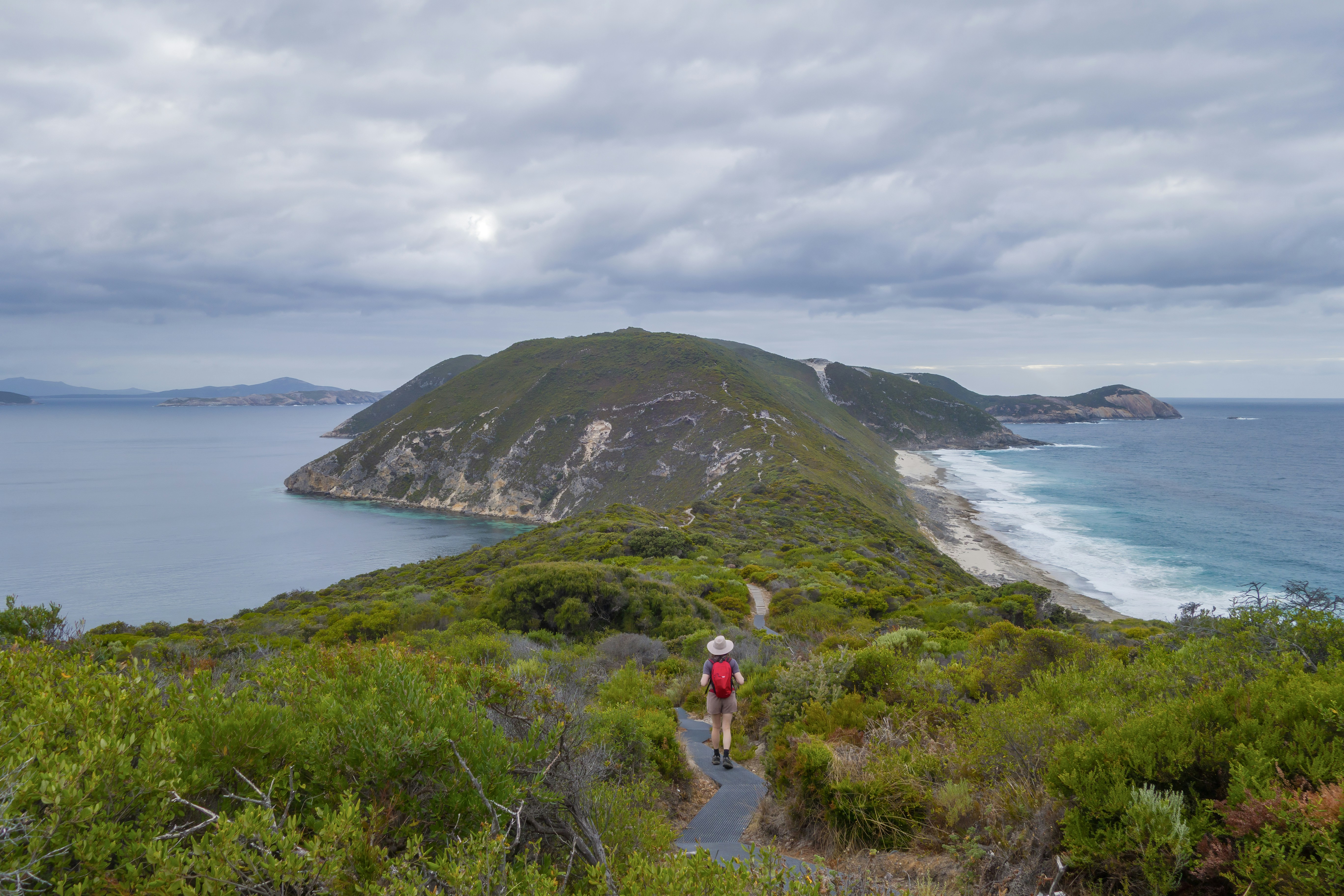 Trail toward a rugged headland over a calm sea
