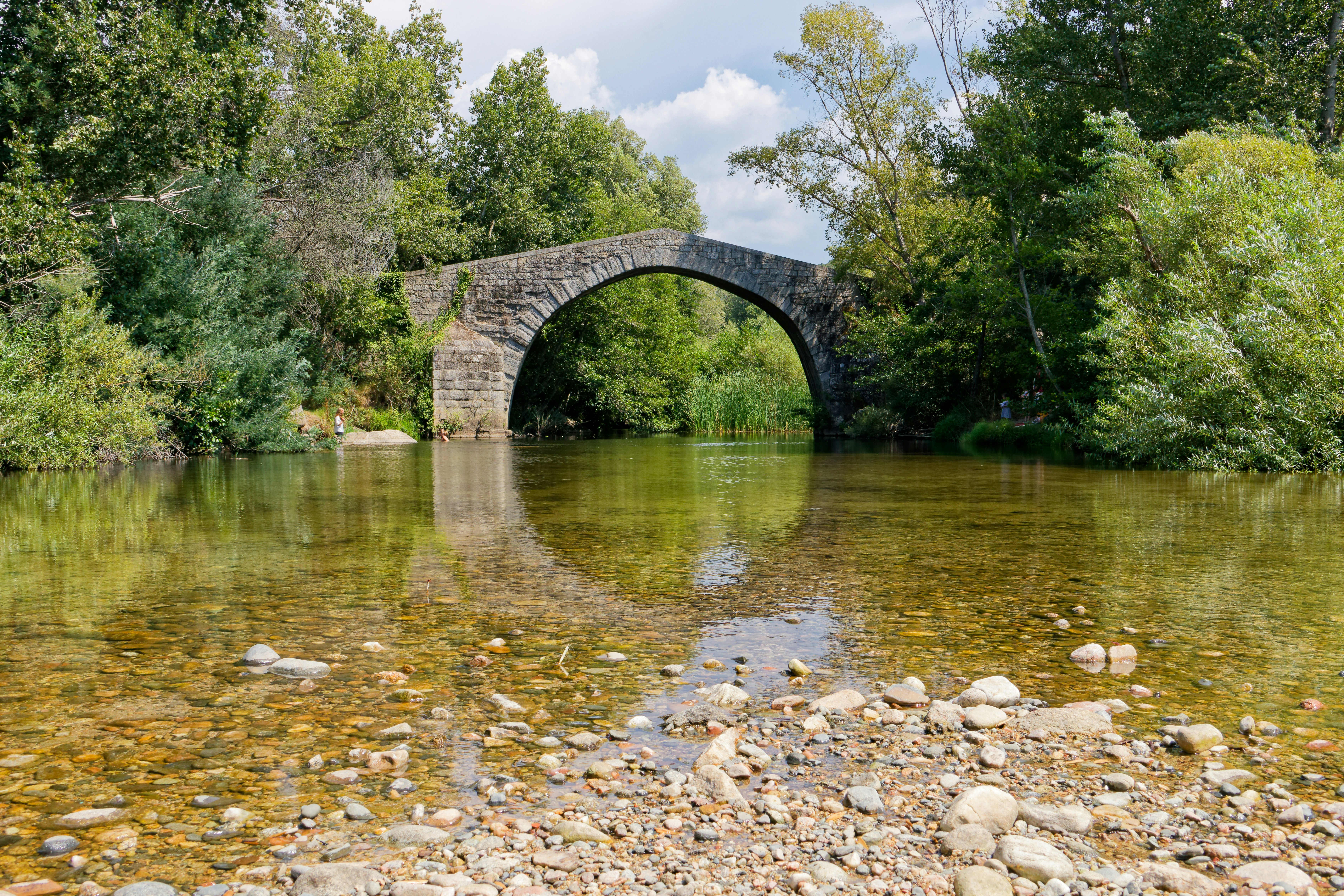 Stone Arc Over Quiet River: A Timeless Bridge Amid Verdant Banks