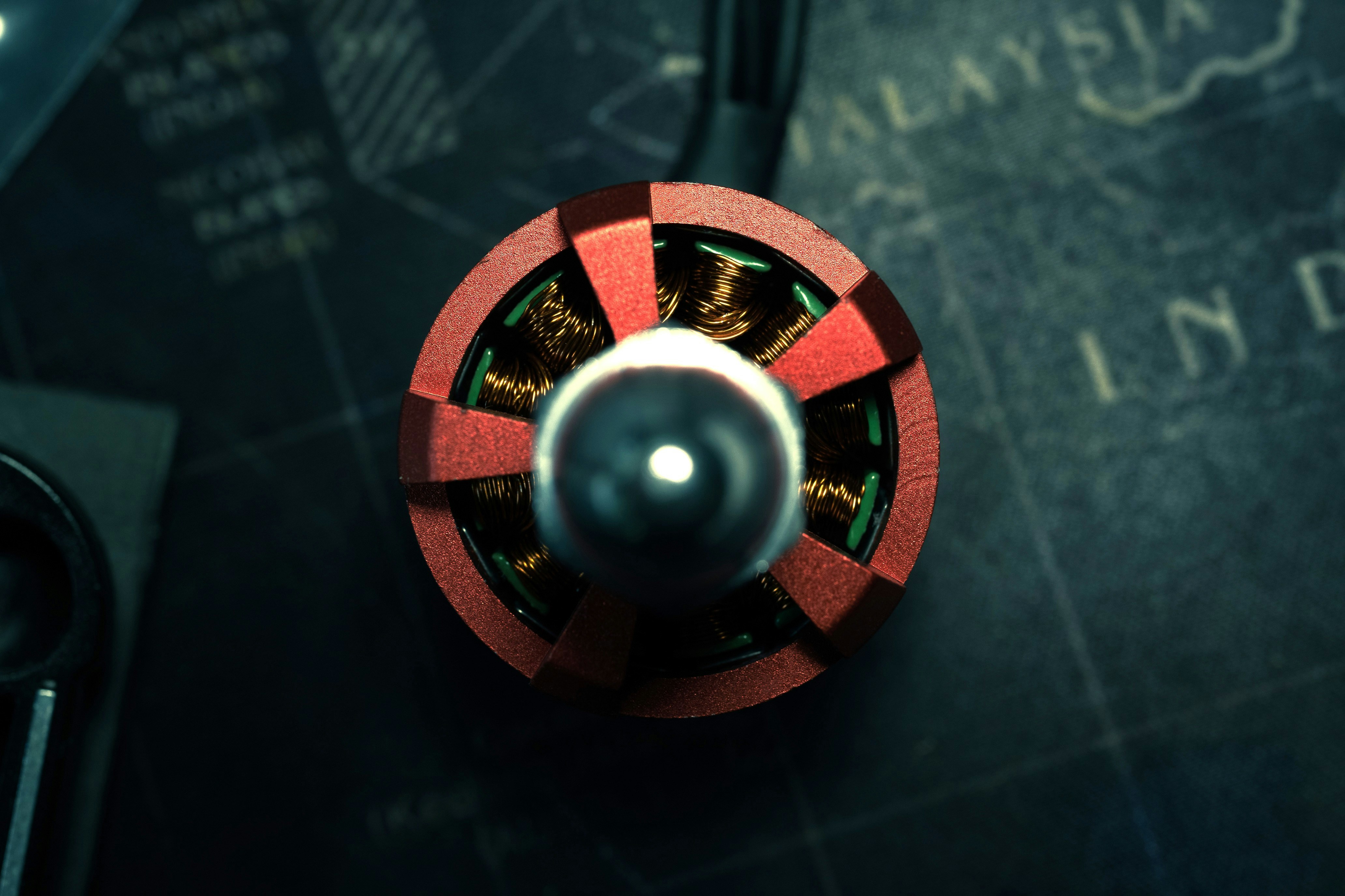 A red and metallic circular device on a dark map.