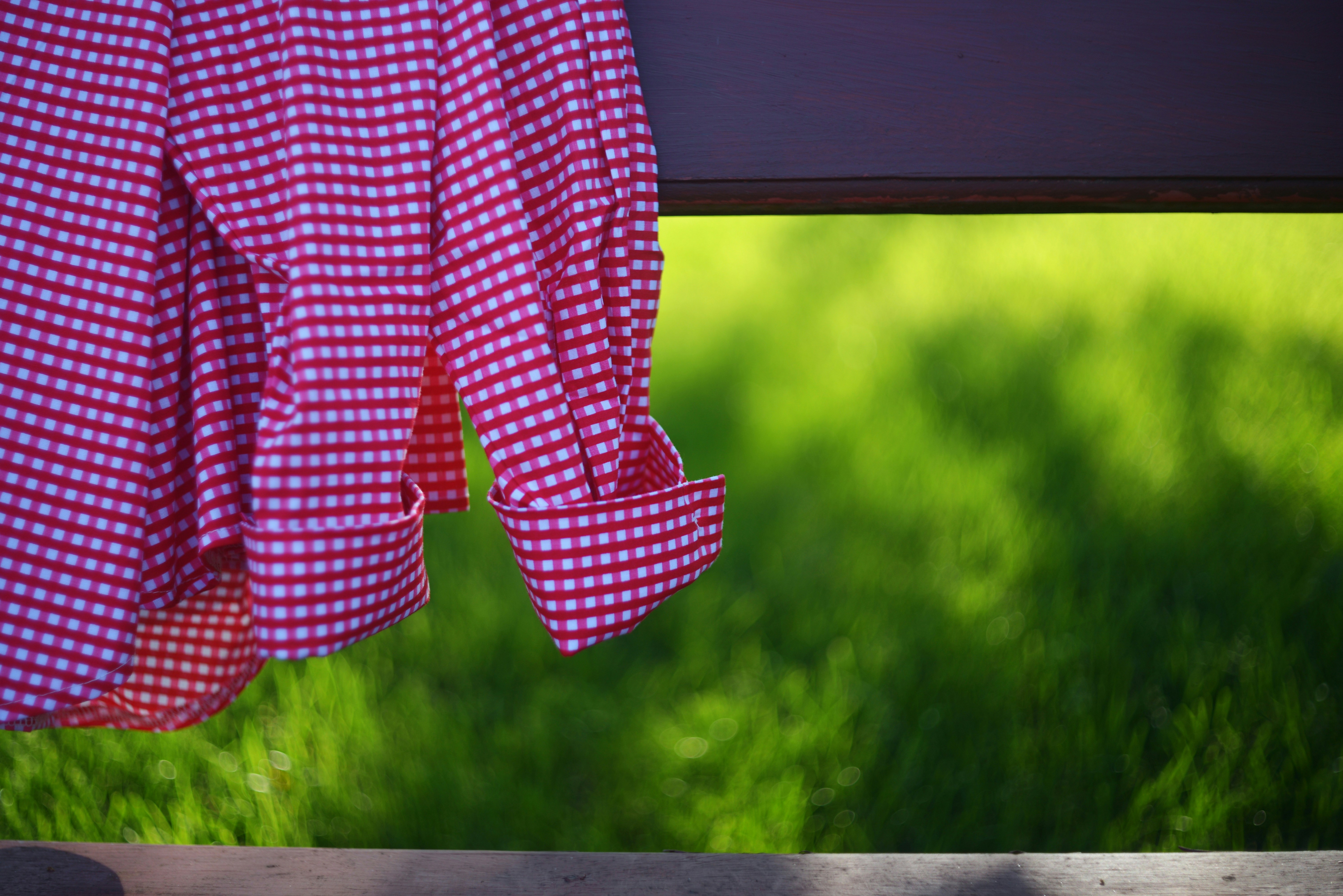 Red-Checked Shirt Draped Over a Railing, Framed by Spring Green