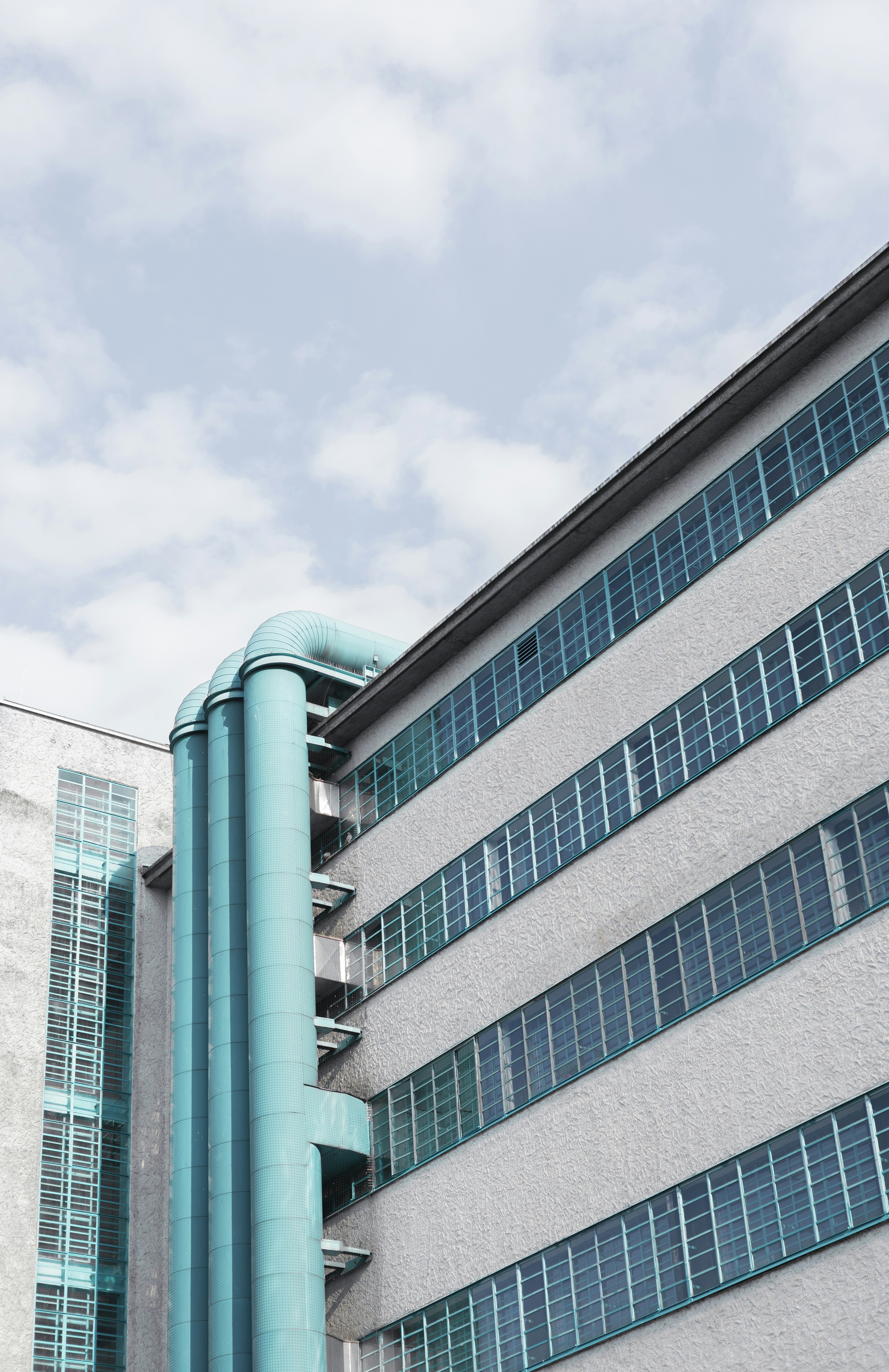 Industrial Geometry: turquoise pipes tracing the building's diagonal