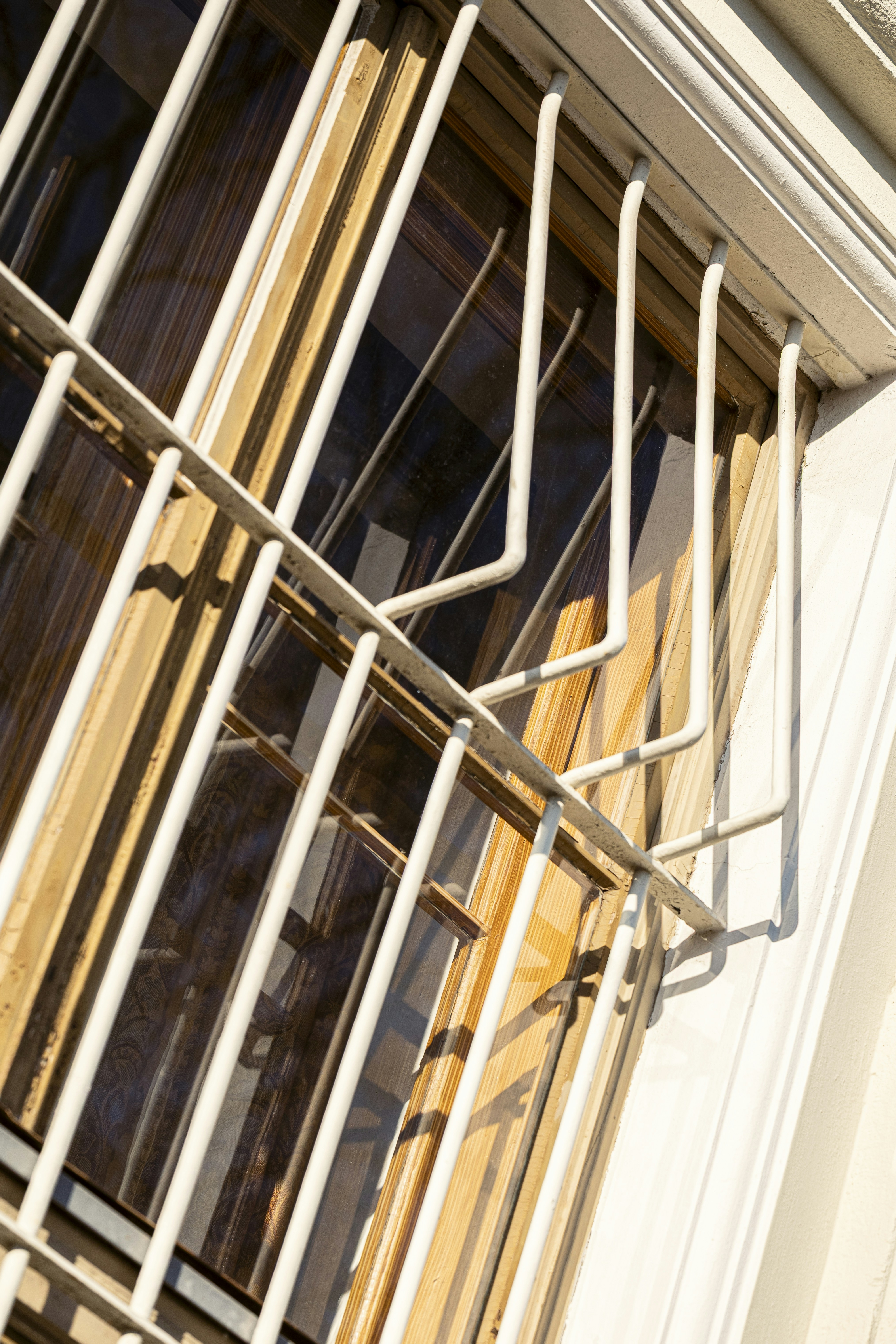 Diagonal Grille Shadows on Sunlit Window Panes