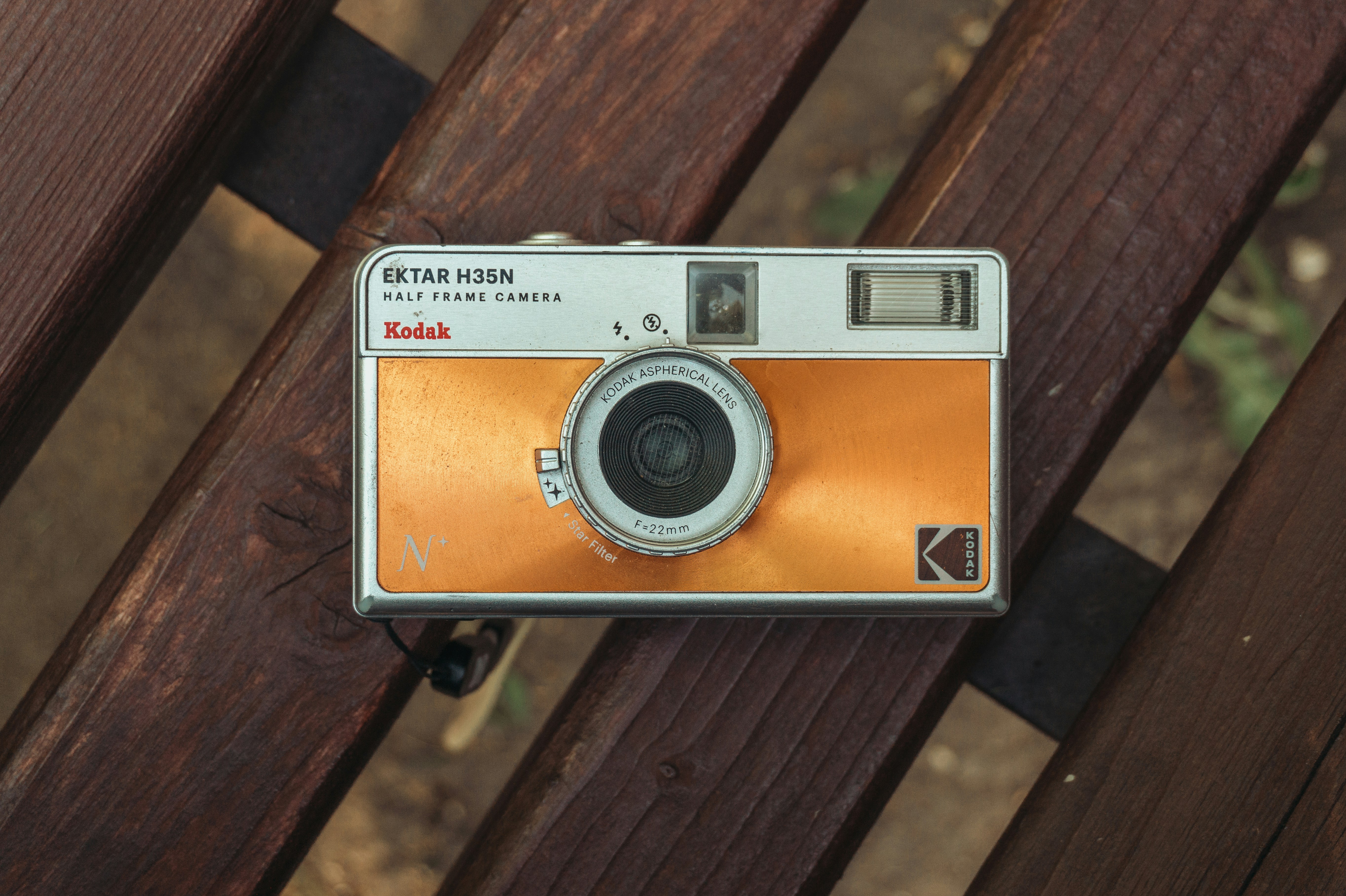 Kodak Ektar Nostalgia: A Copper-Burnished Compact Resting on Wooden Slats