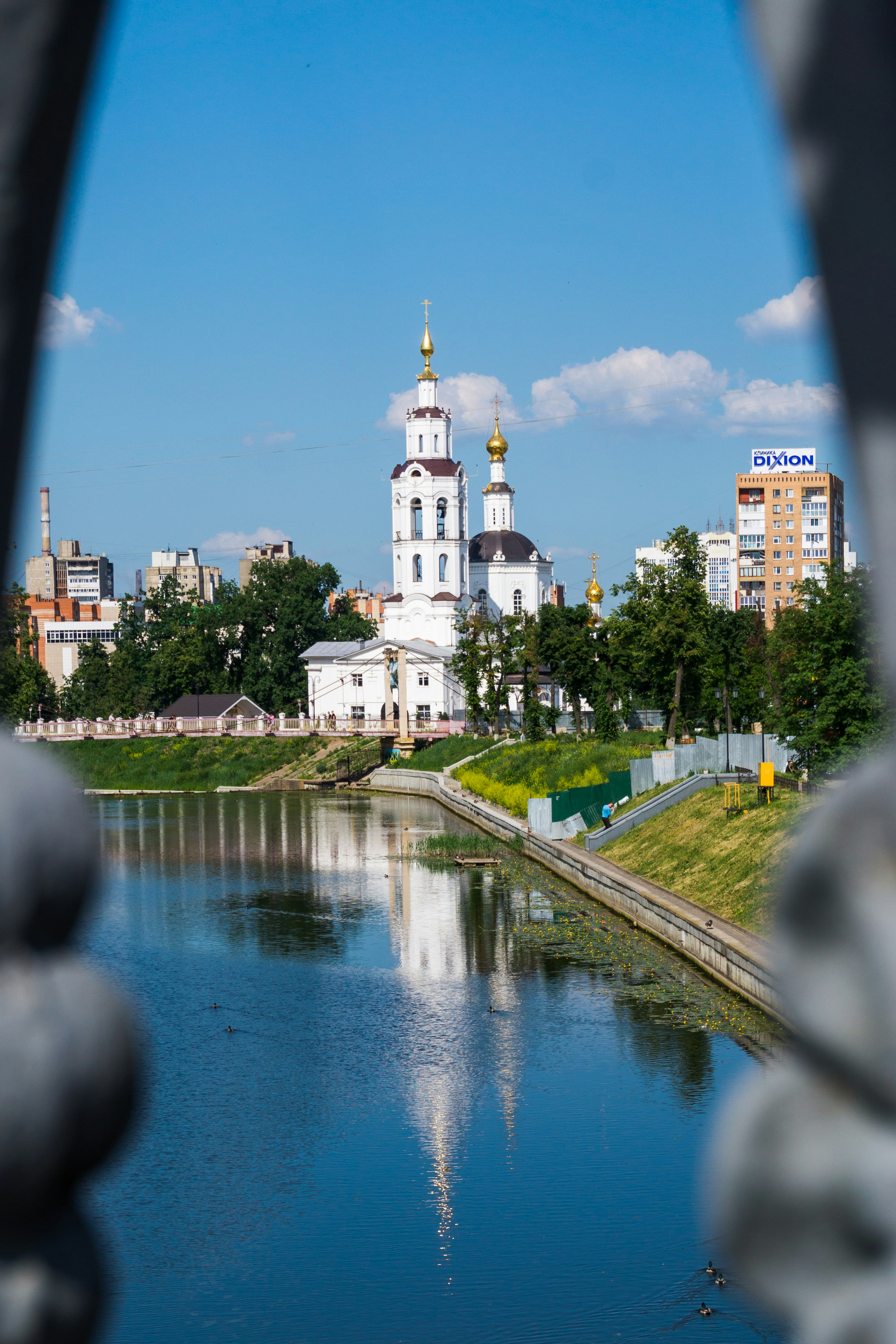 Golden-domed church rising above the riverbank framed by urban skyline