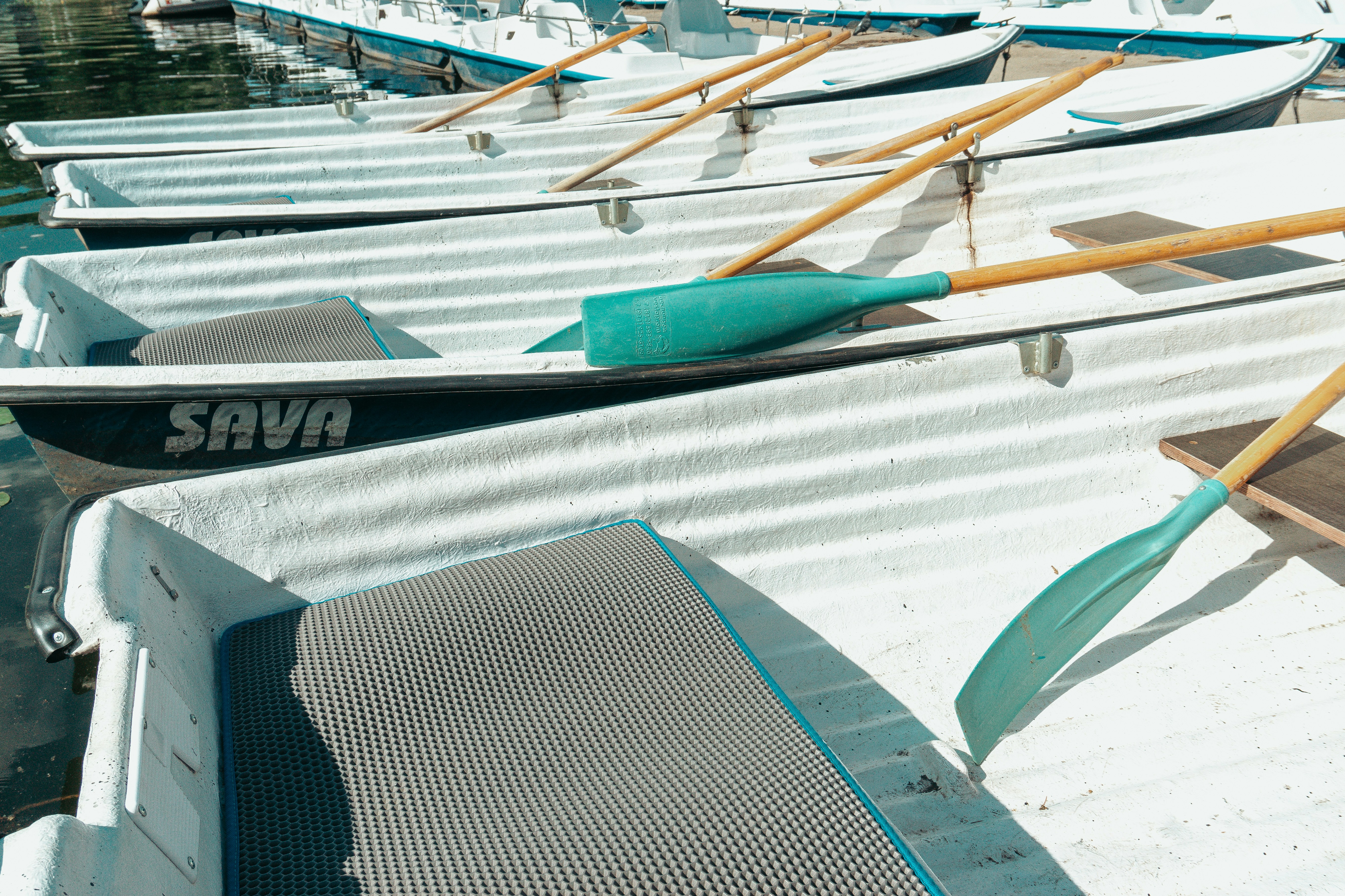 Oars Resting Across Rowboats in Sunlit Marina