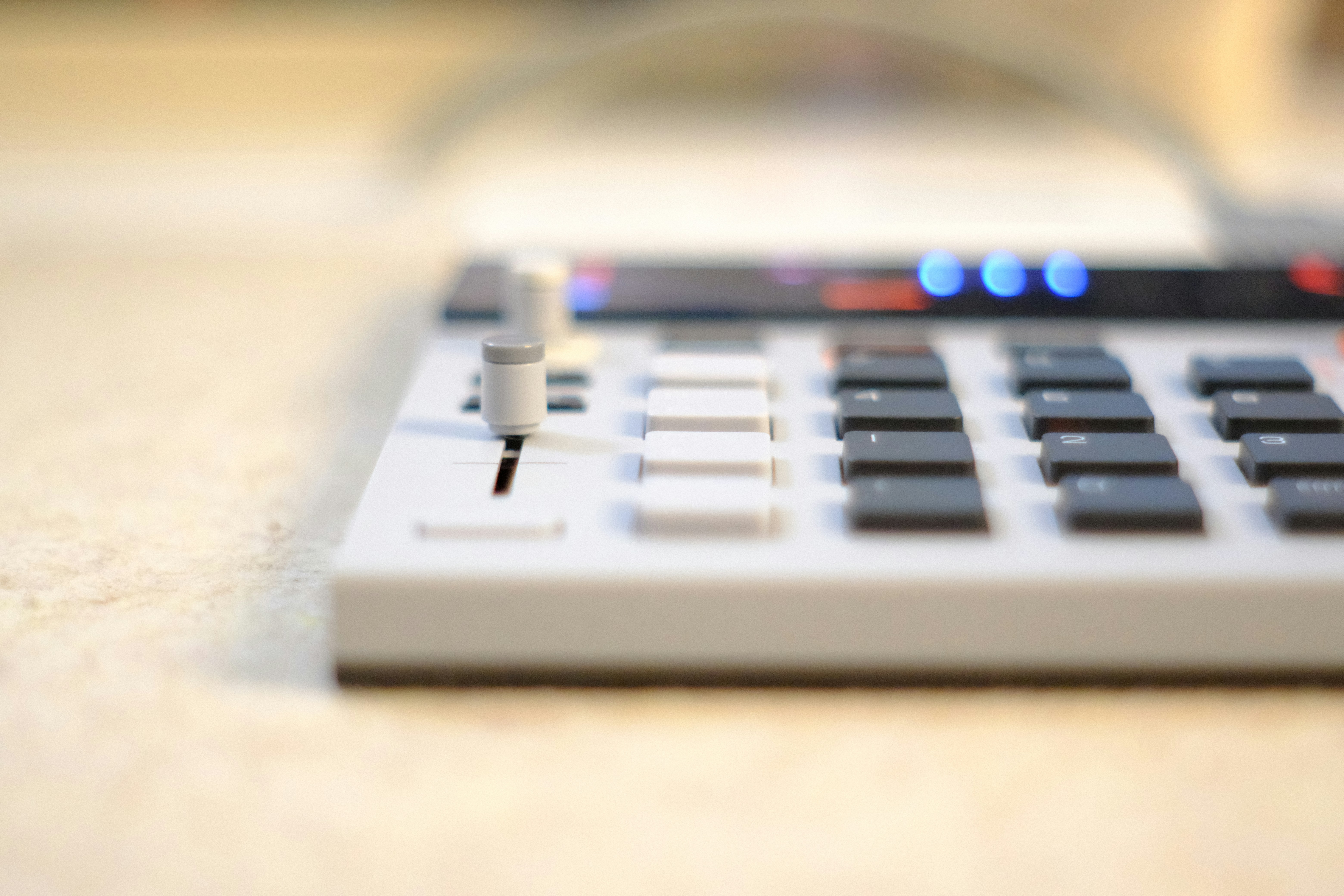 Close-up of a vintage-style music surface: tactile fader and pad layout