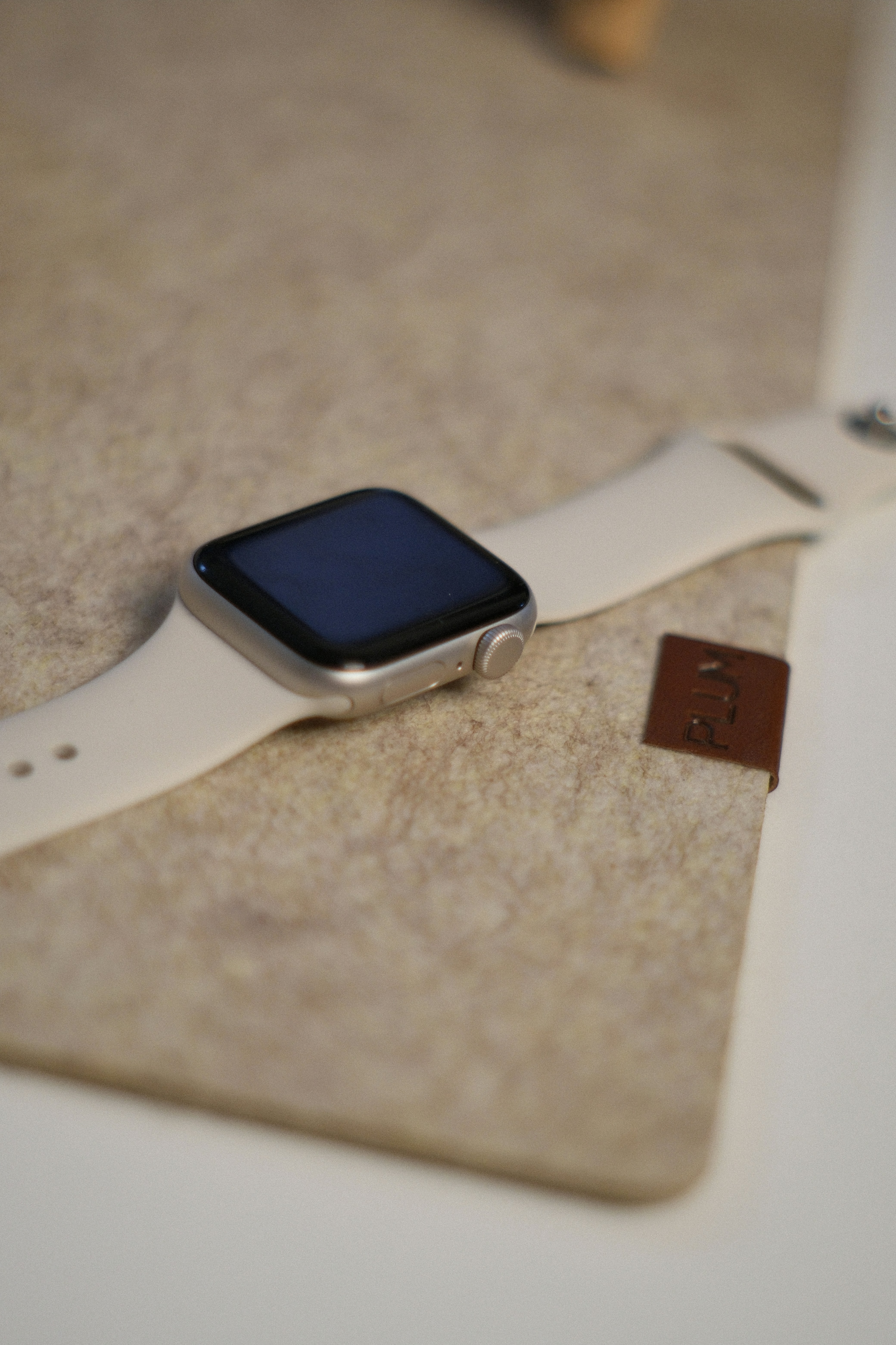 Rugged Elegance: A White-Silicone Apple Watch Resting on a Soft-Tone Mat