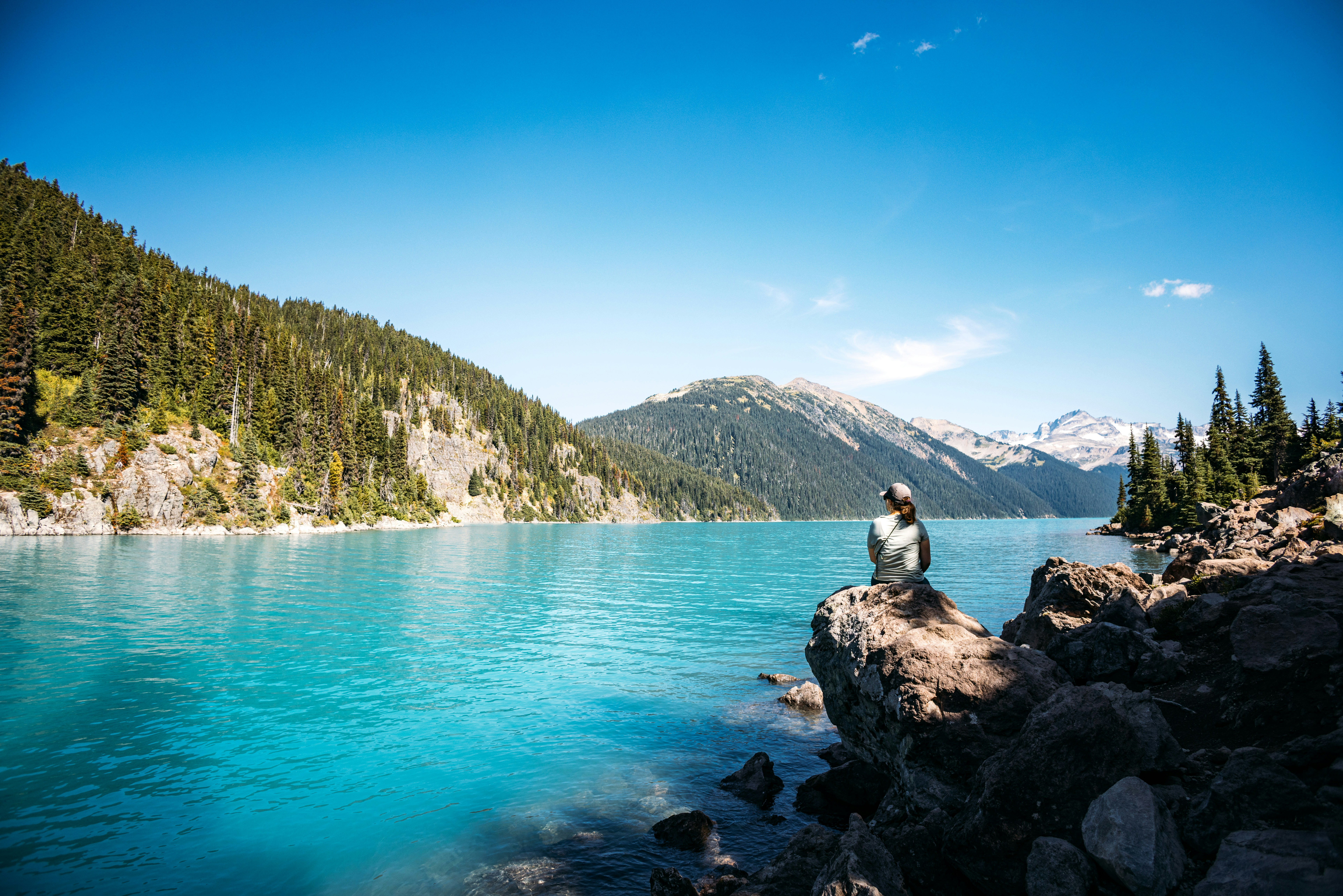 Lone Hiker Reigning Over Turquoise Alpine Reservoir