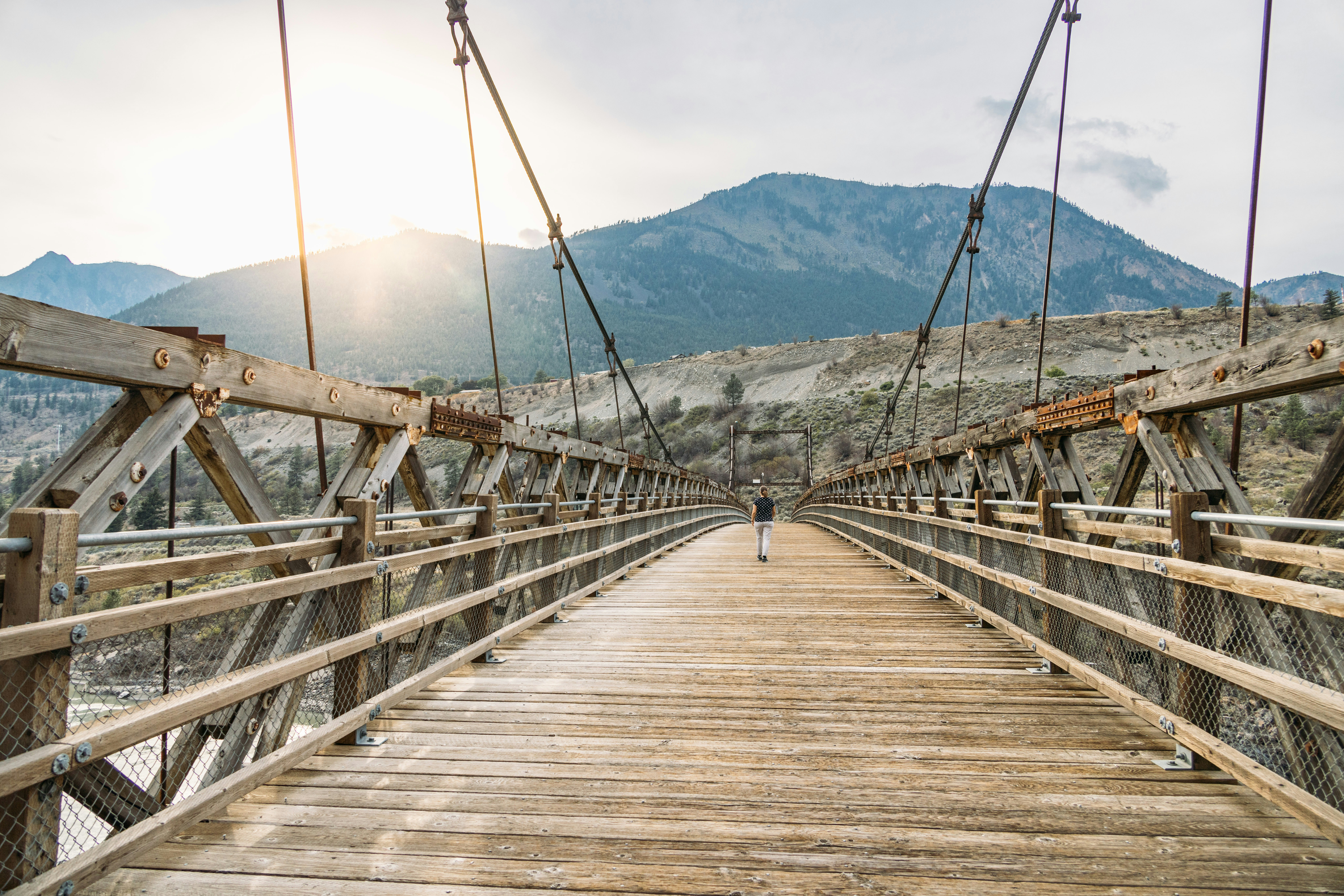 Bridge to the Valley Loom: A Lone Walker Beneath Open Sky