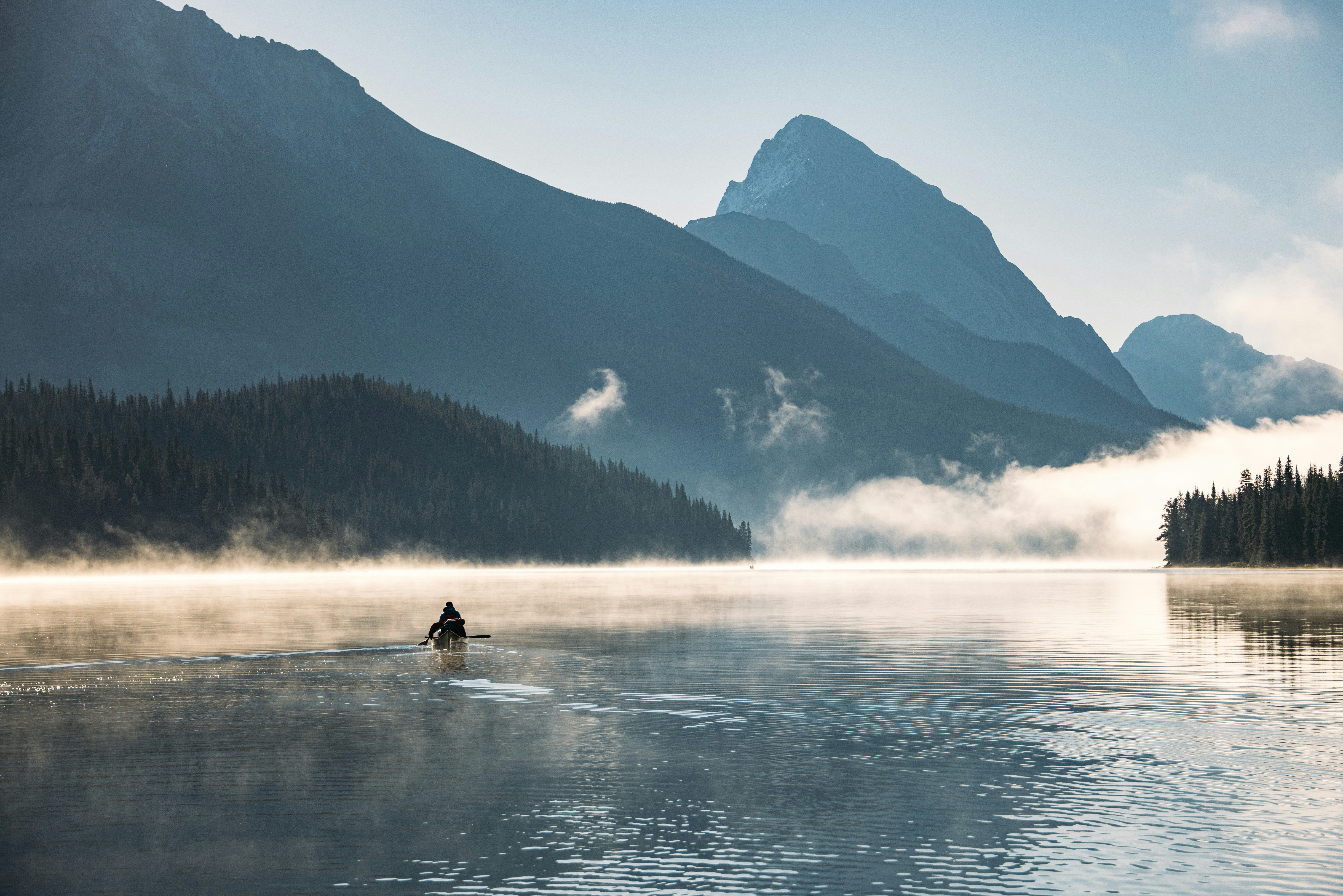 Mist-kissed Dawn: A Lone Paddler on a Serene Alpine Lake