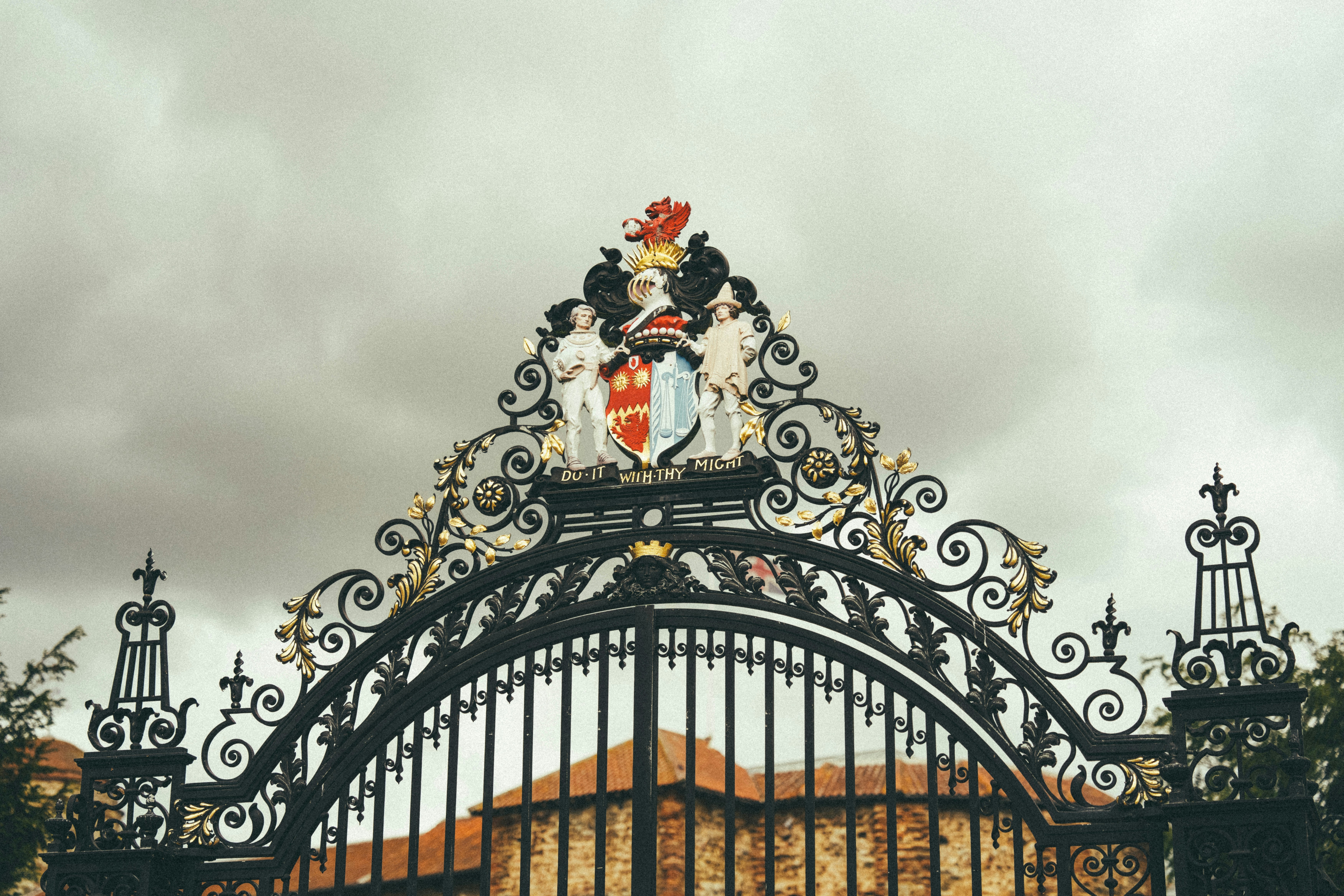 Heraldic Gate: Ornate Crest Above Iron Lattice