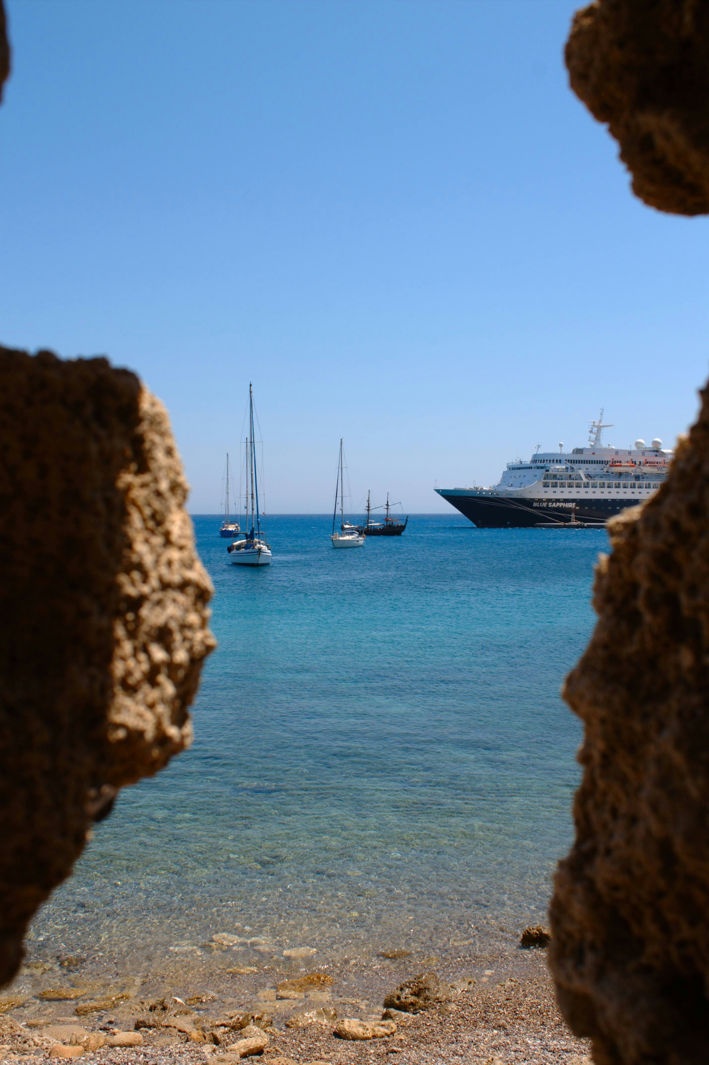 Harbor Vista: Boats at Sea Framed Between Cliff Gaps