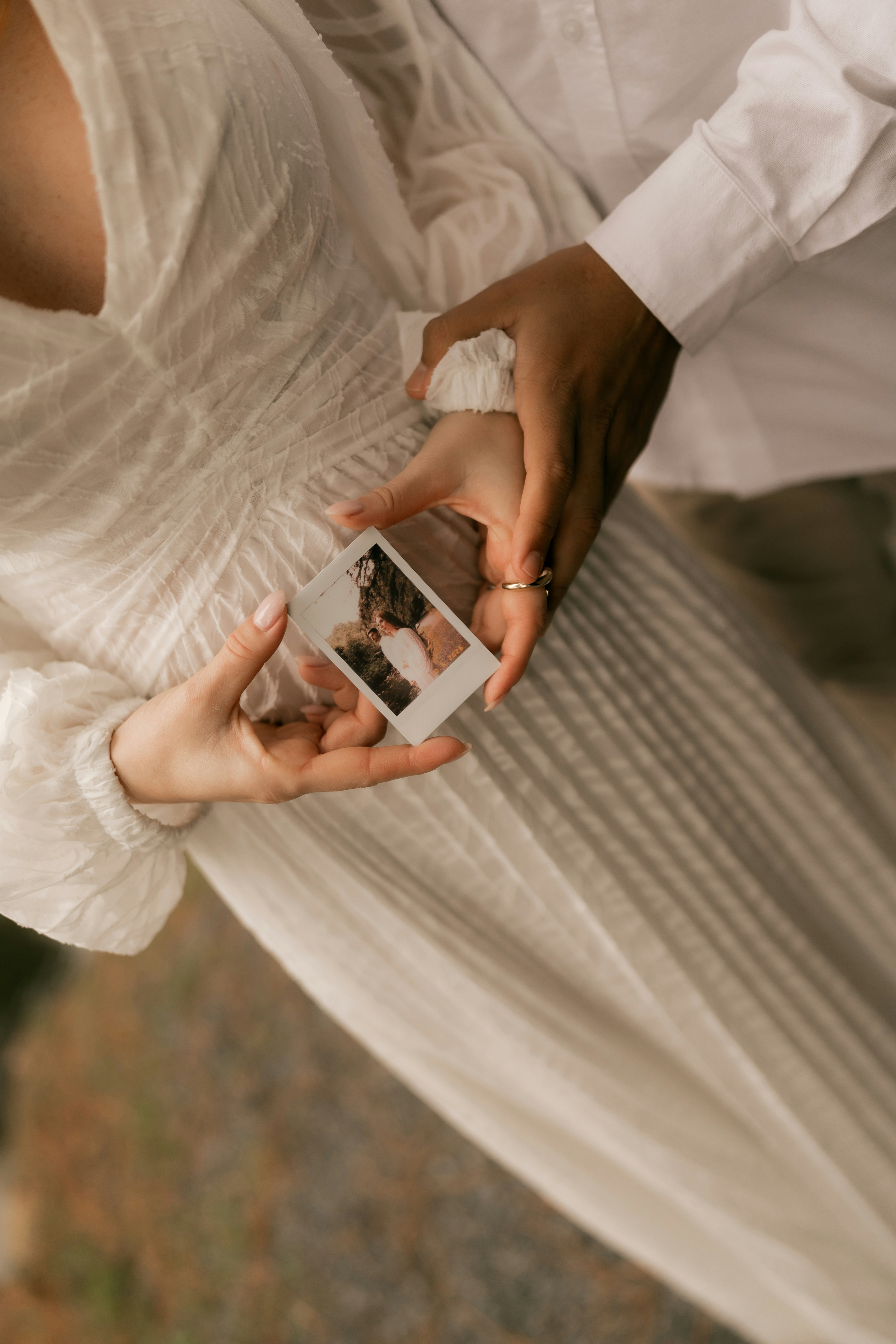 Holding Moments: A Gentle Exchange of a Polaroid in Soft Light