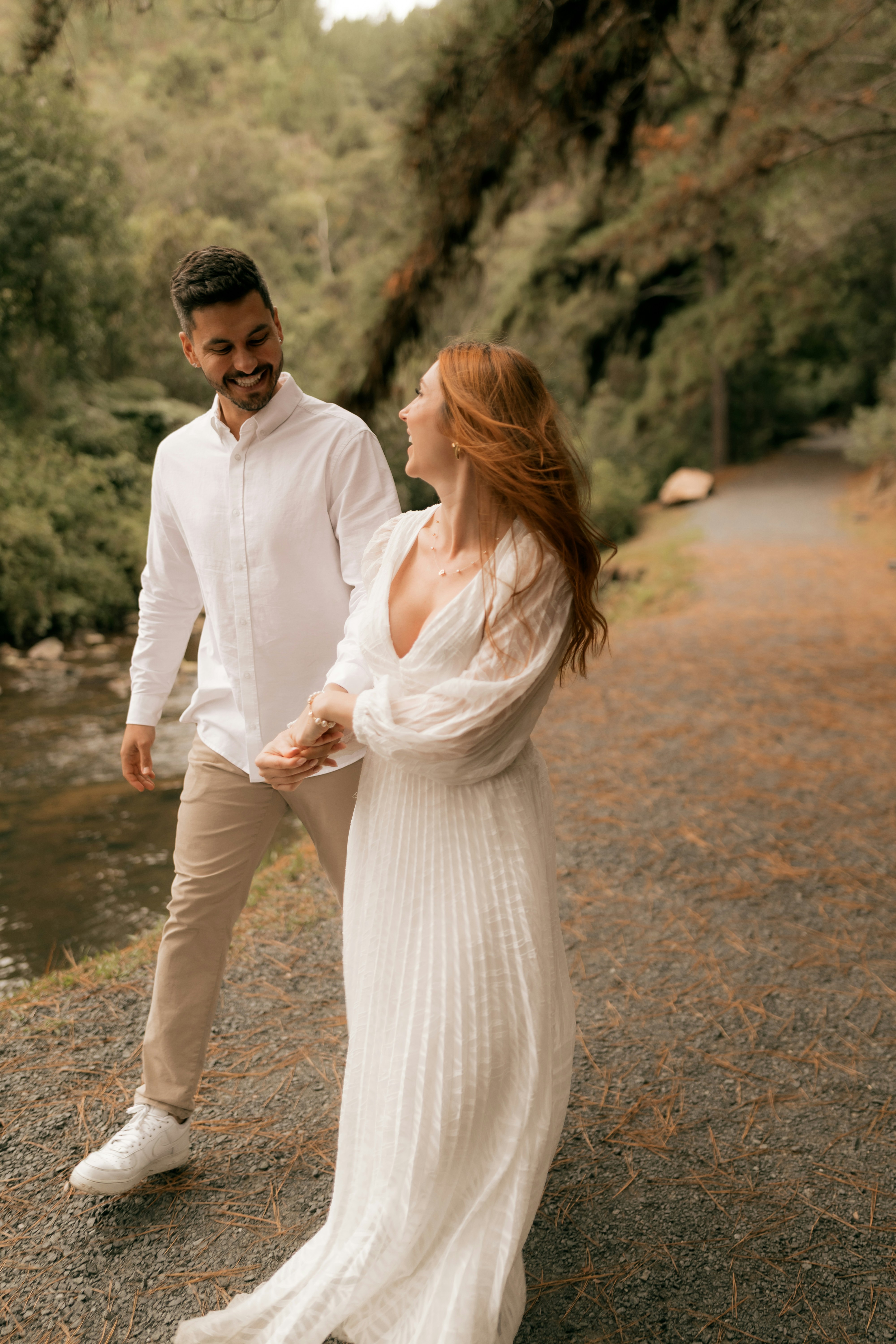 Veil of Autumn Light: A Couple Strolls Hand in Hand Through a Forest Path