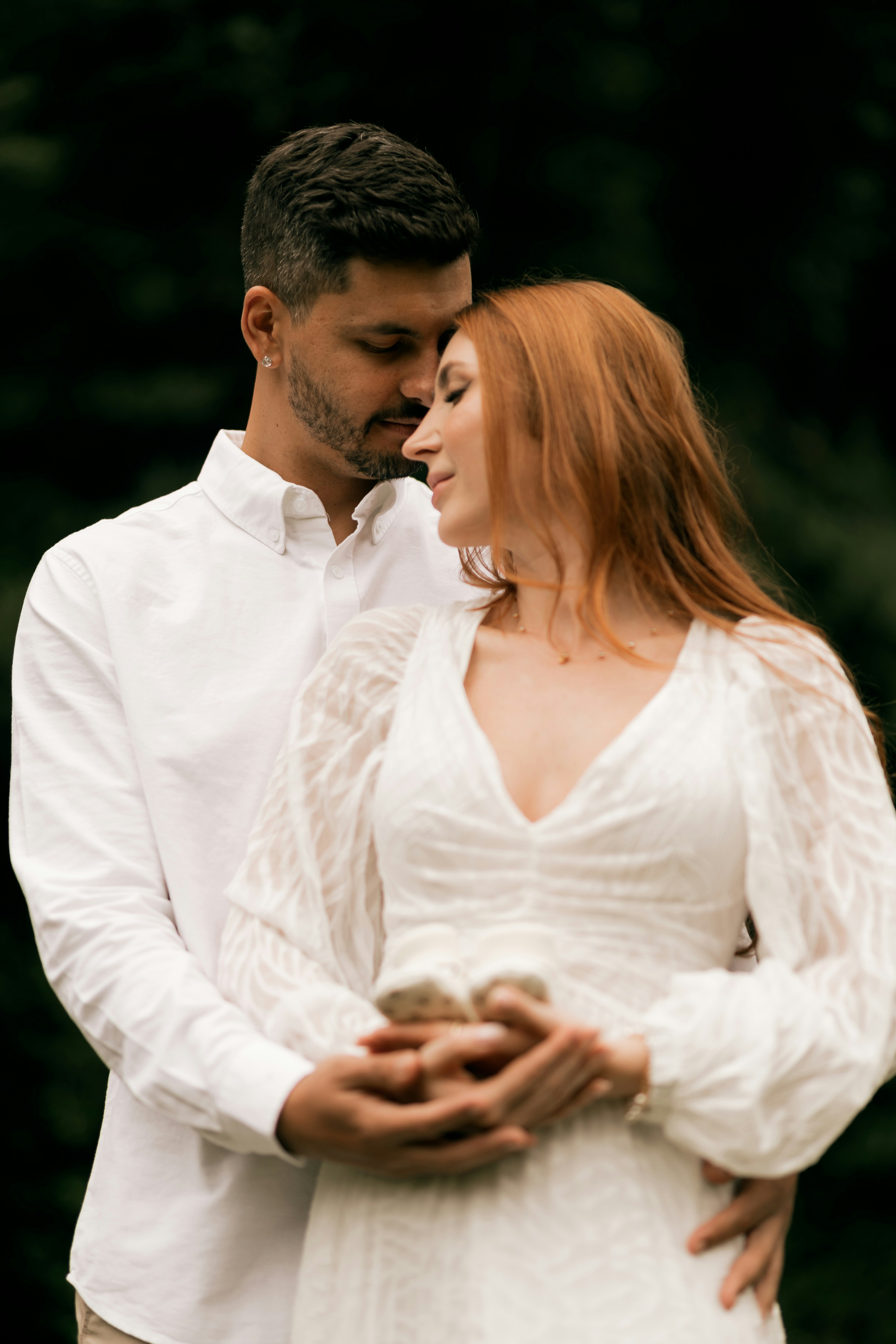 Young couple embracing affectionately outdoors.