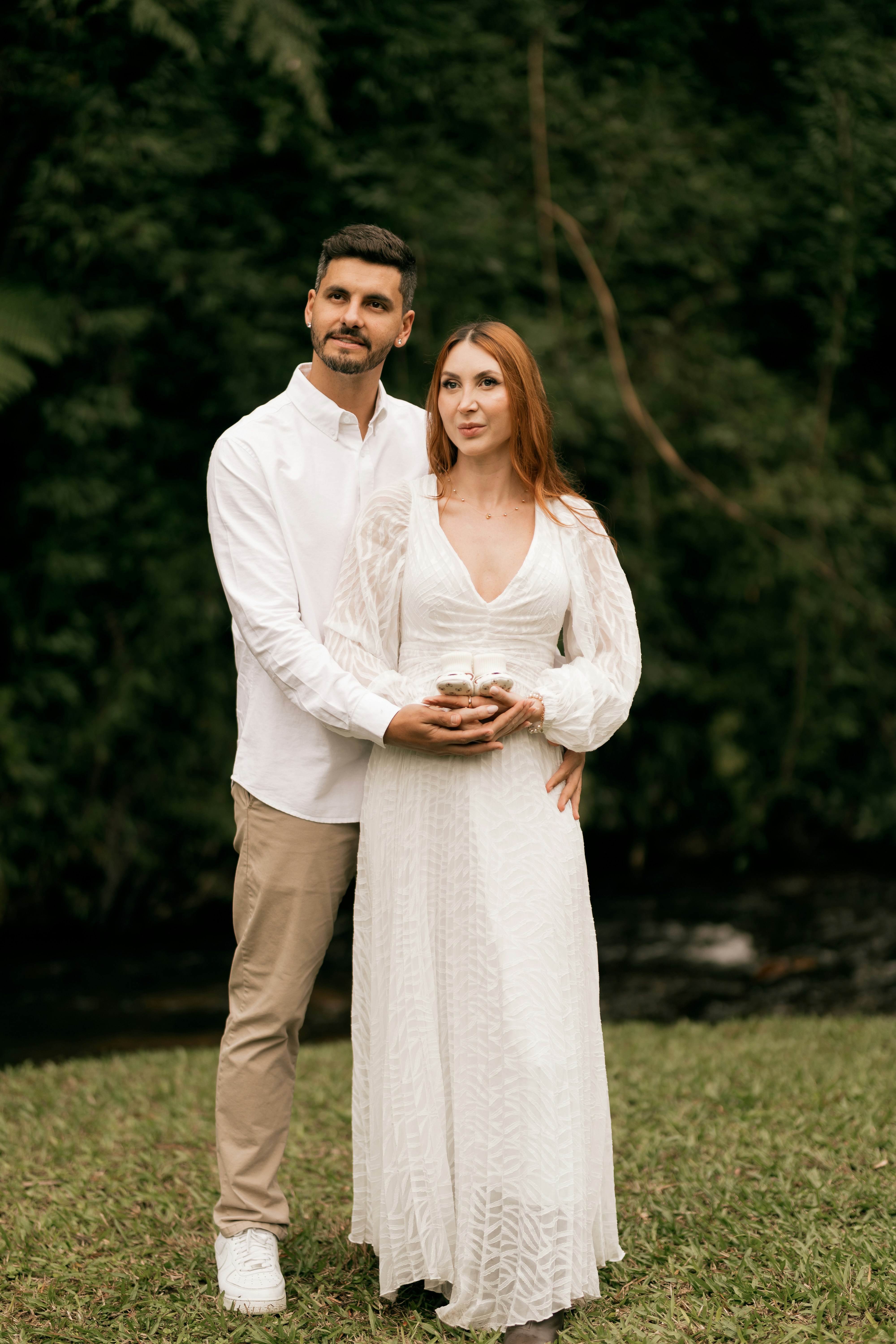 A couple embracing outdoors in a green park.