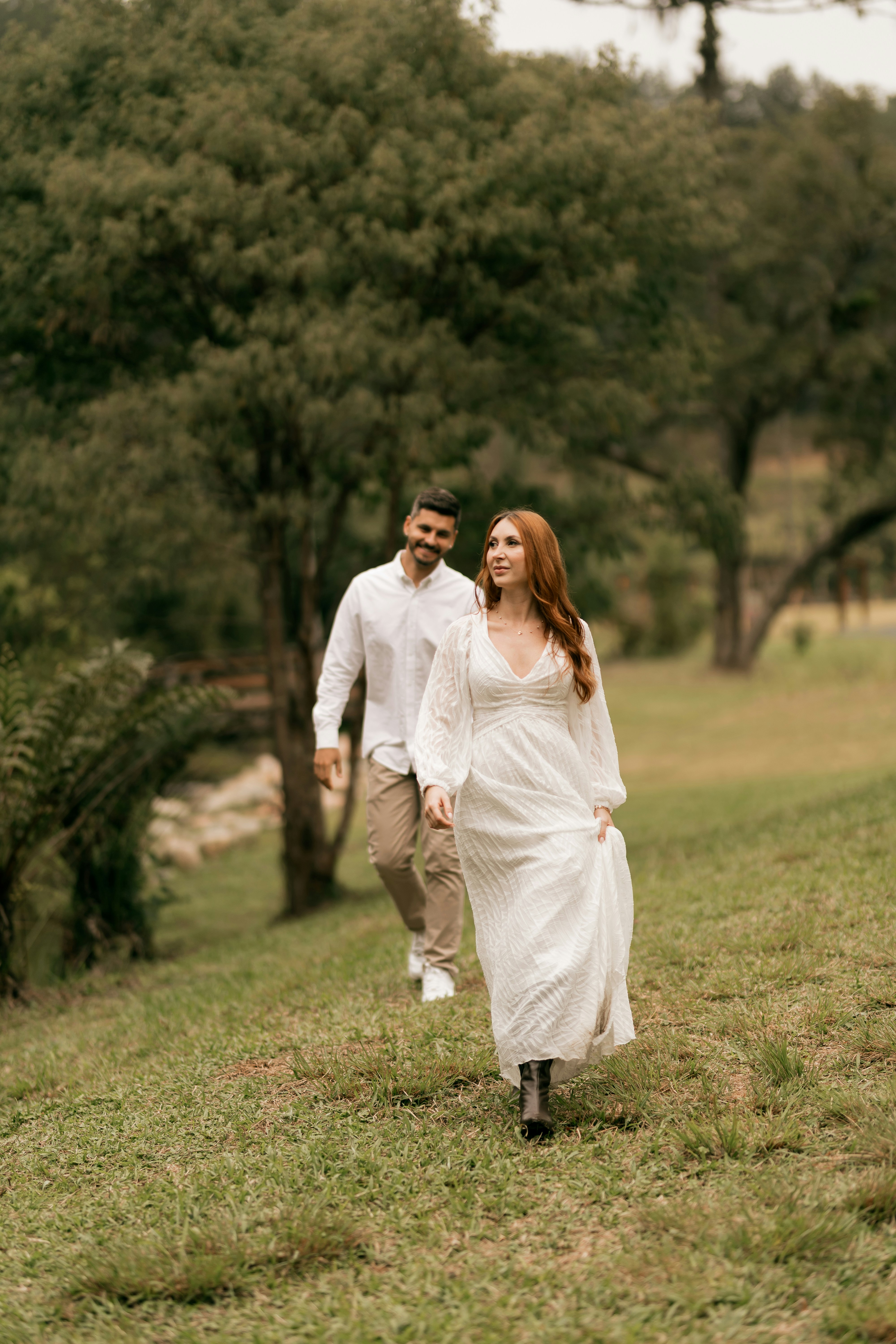 Happy couple strolling through a lush, green park.