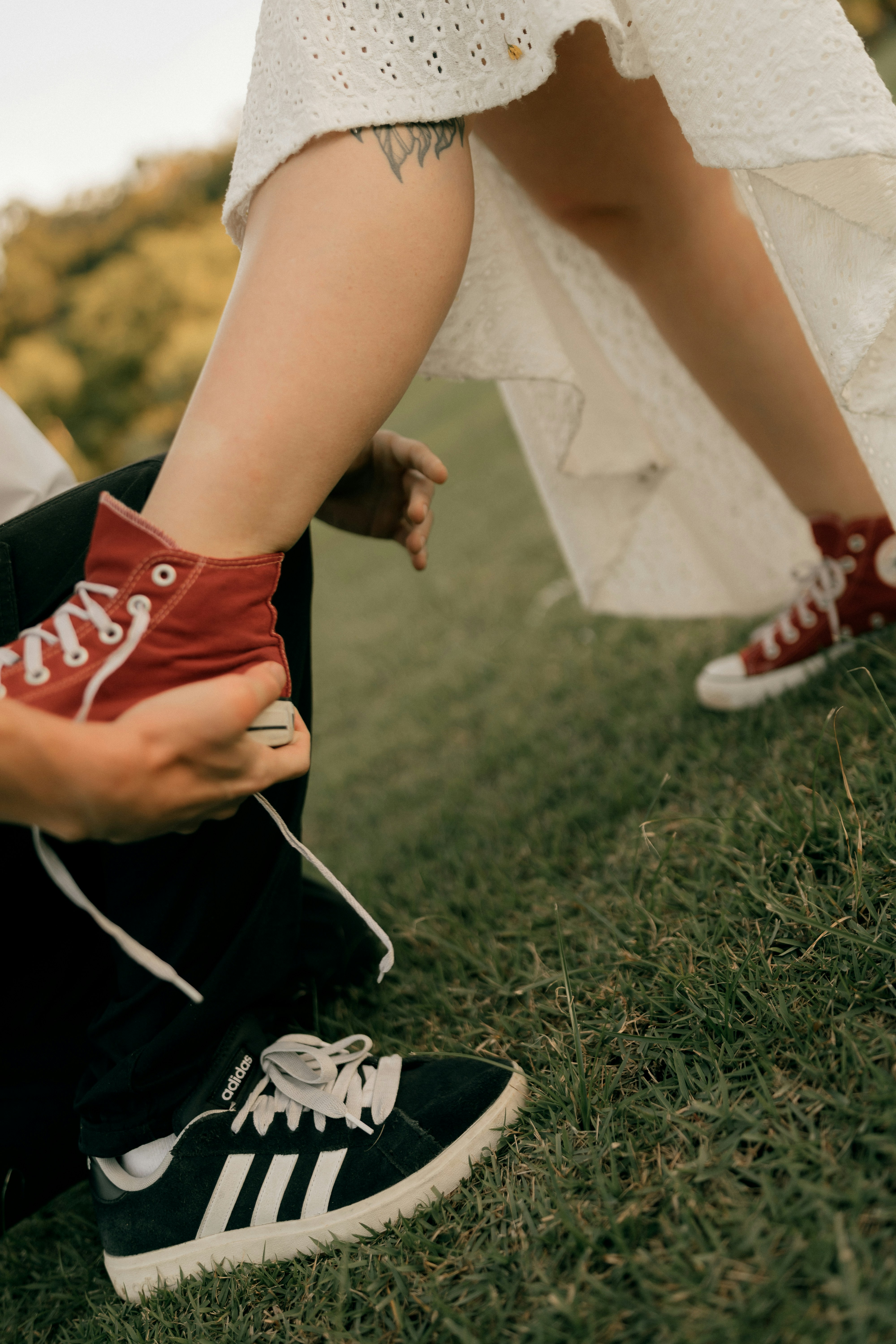 Red Sneakers, White Dress, and a Moment of Tied Laces