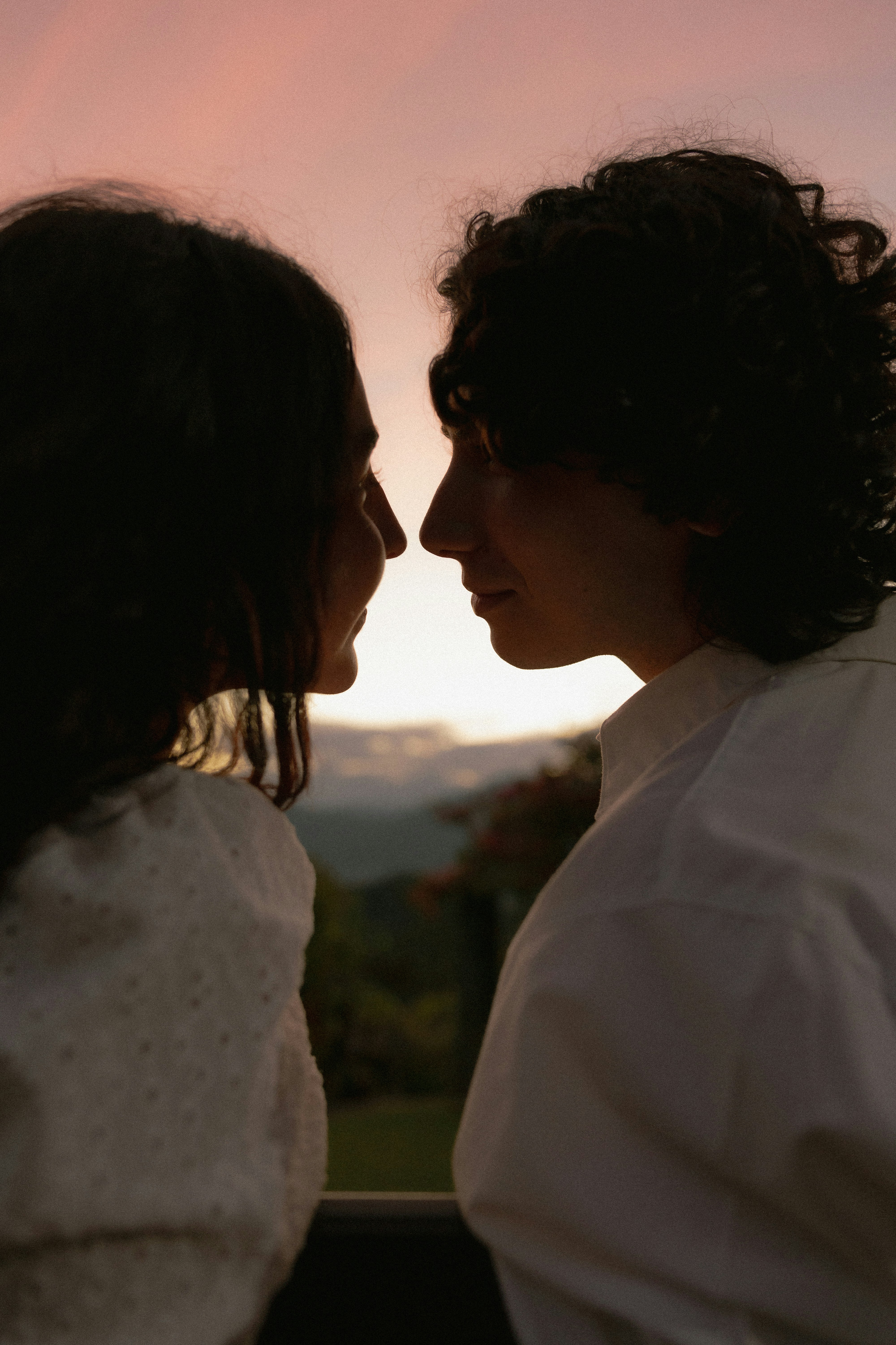Silhouetted couple gazing at each other during sunset.