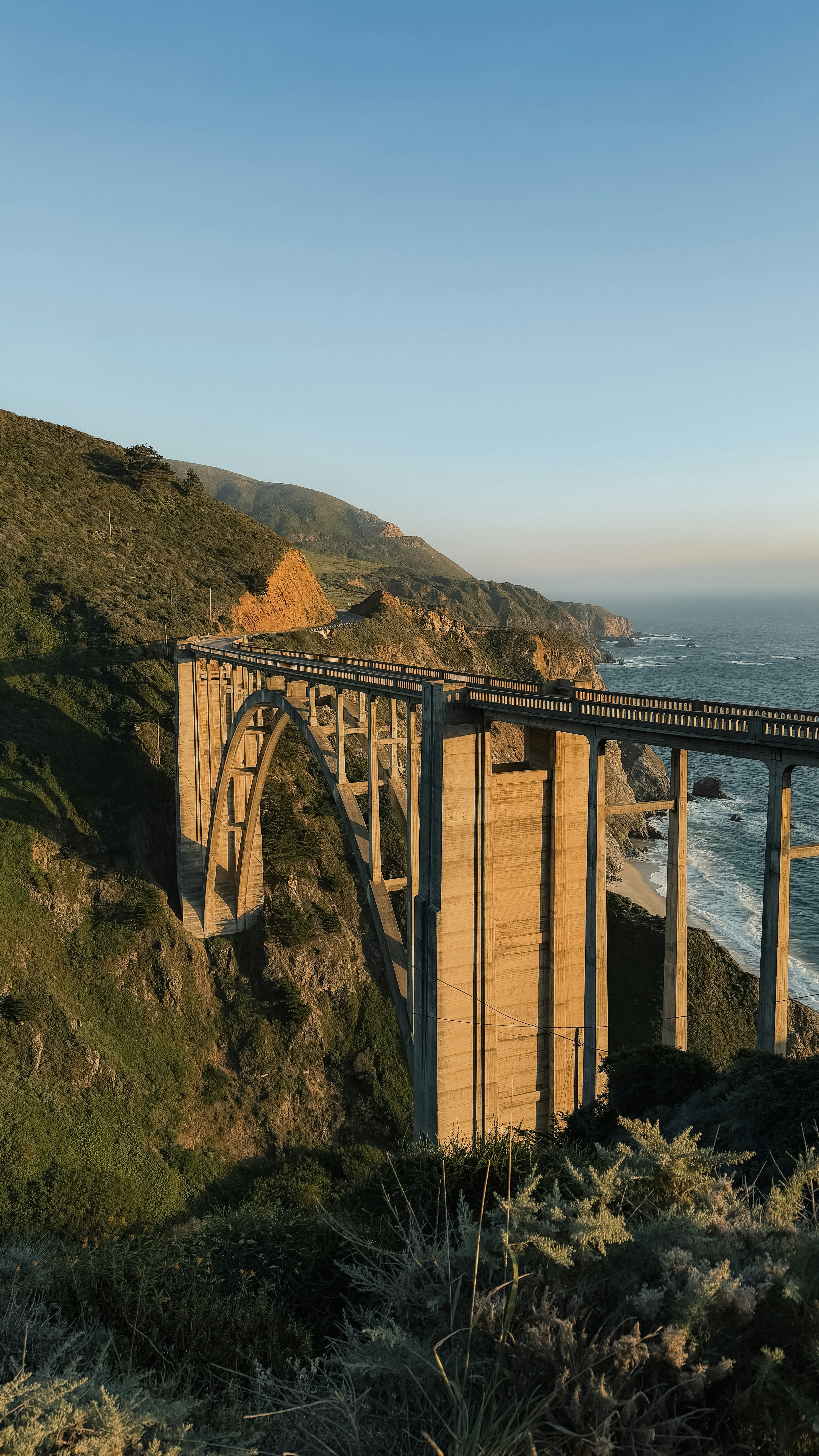 Sunlit coastal viaduct carved into the cliffs