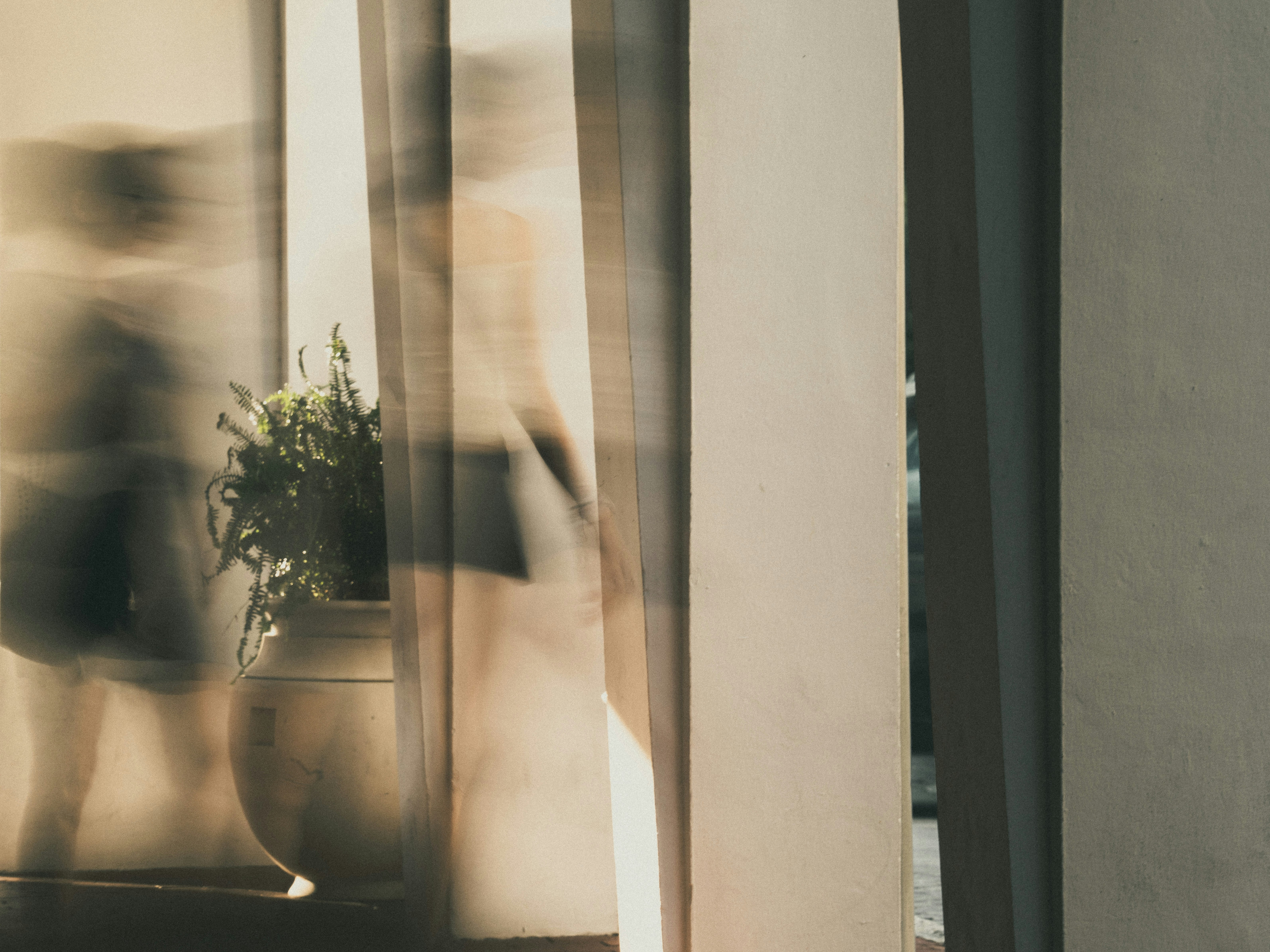 Motion blur and anonymous figures moving through architectural spaces in a modern urban environment.
