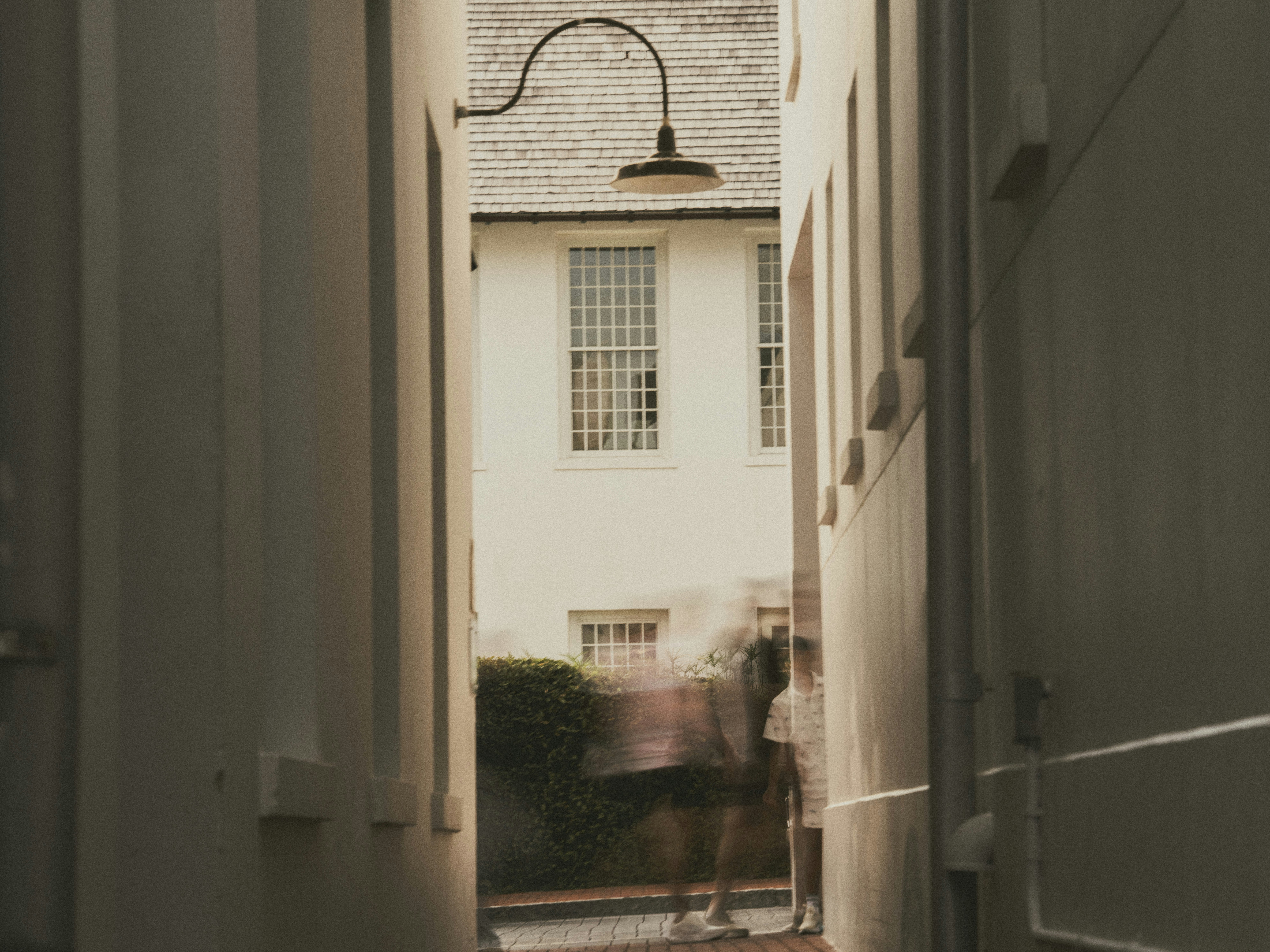 Motion blur and anonymous figures moving through architectural spaces in a modern urban environment.