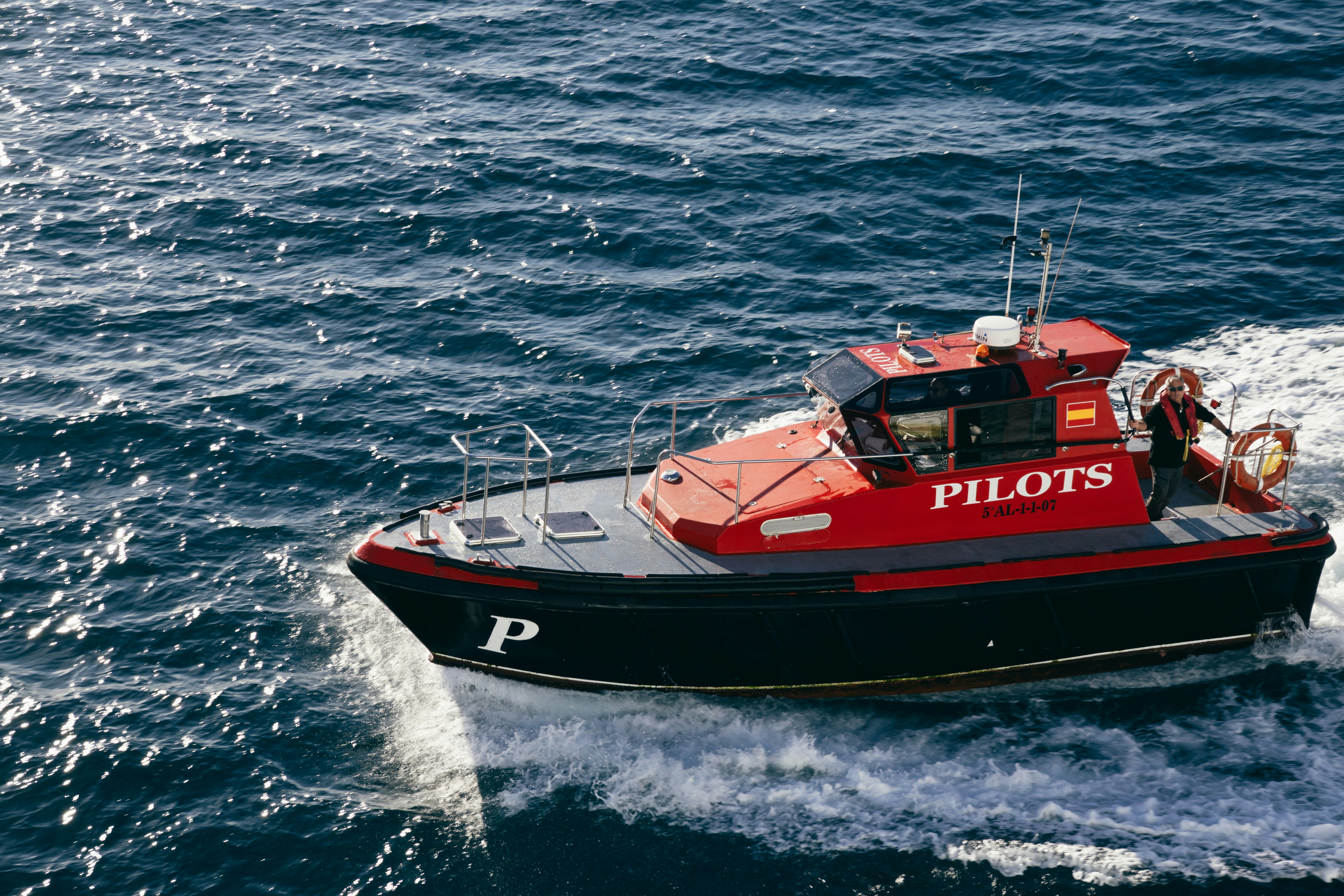 Red Pilot Boat Cutting Through Blue: Aerial View of a Coast Guard Vessel in Action