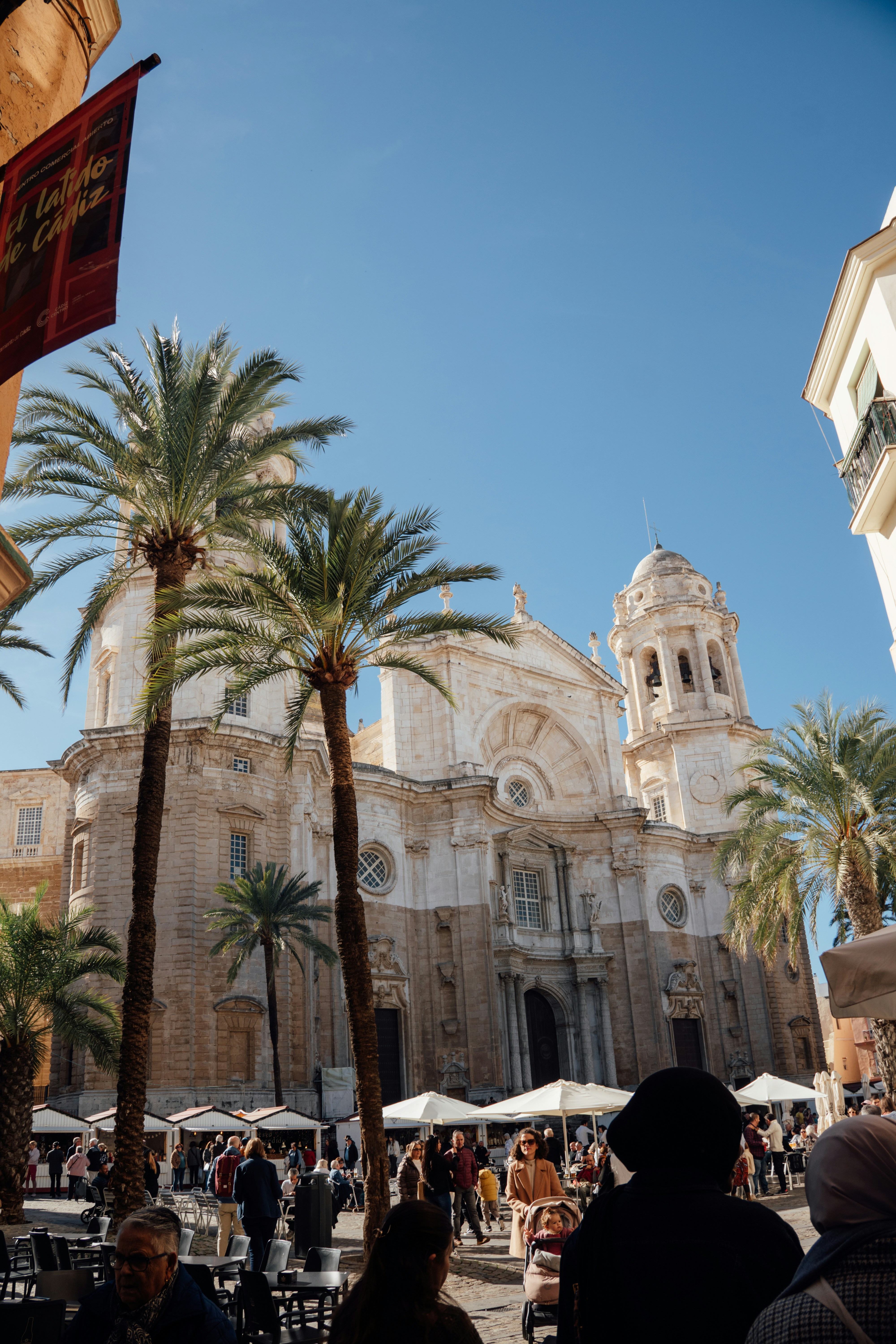 Cathedral Square: Palm Shadows and a Crowd Beneath Arcaded Facades