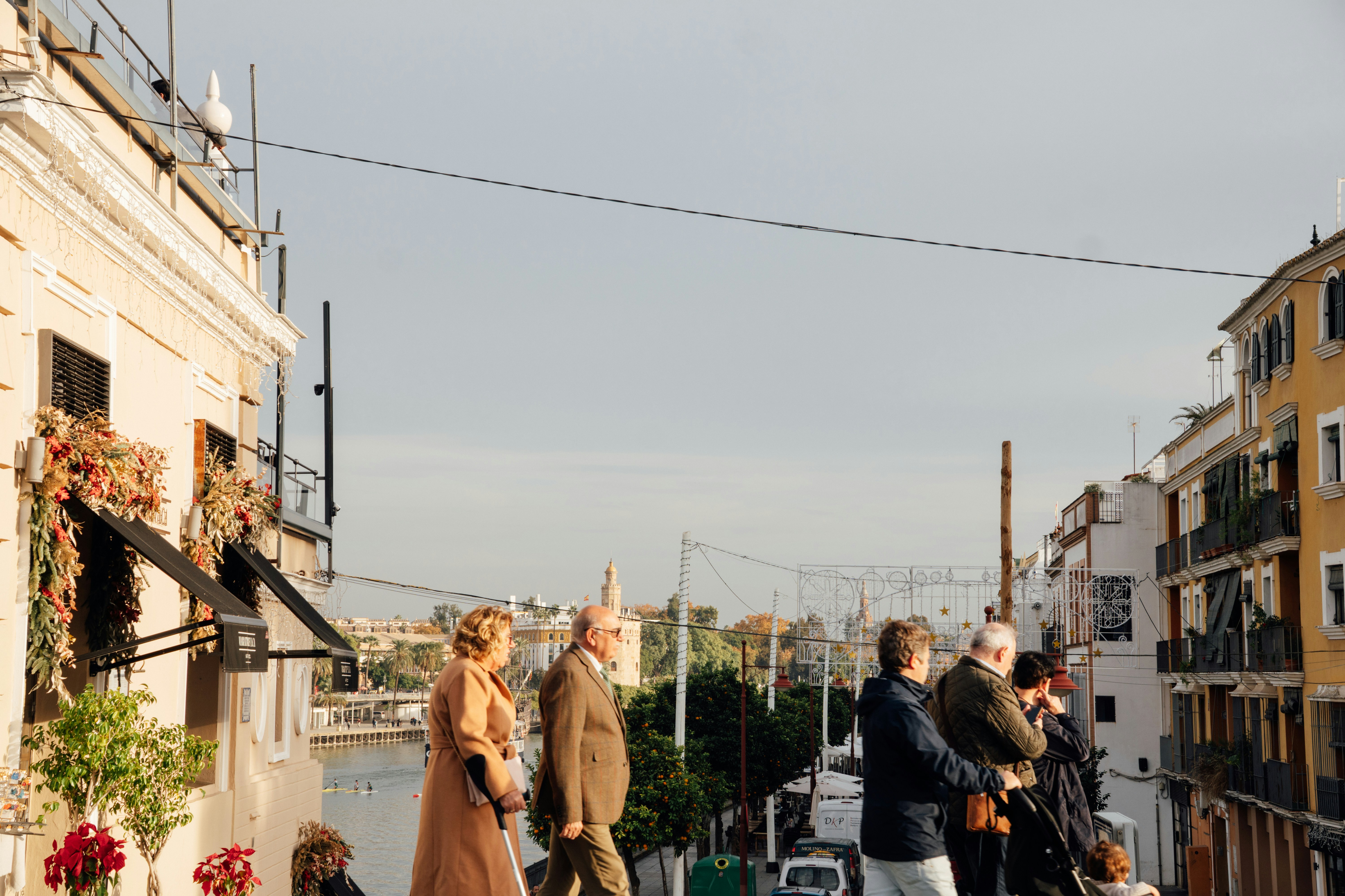 Sunlit Balcony Walk: Social Moment Above a Mediterranean Street