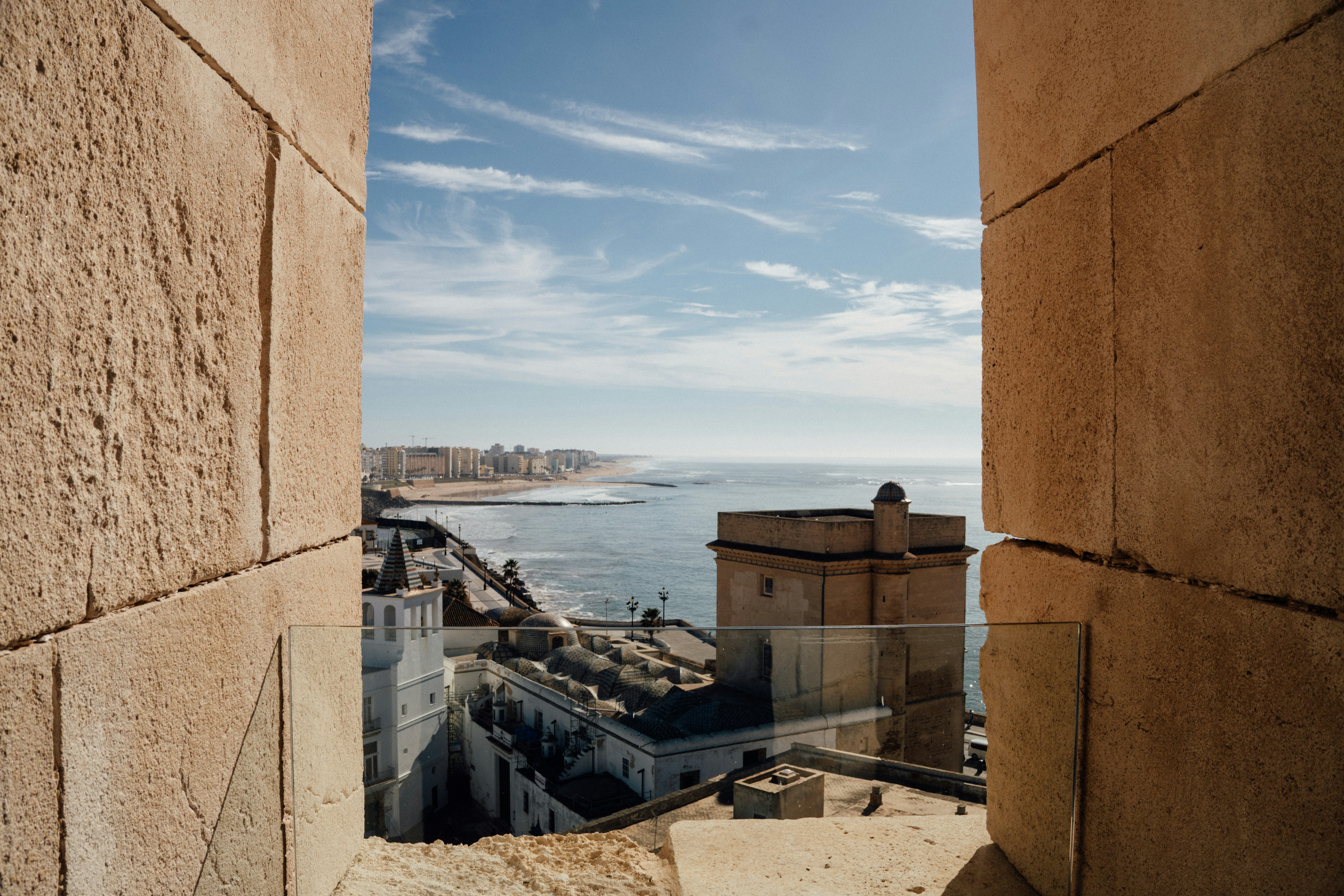 View of the ocean and city through a stone window.