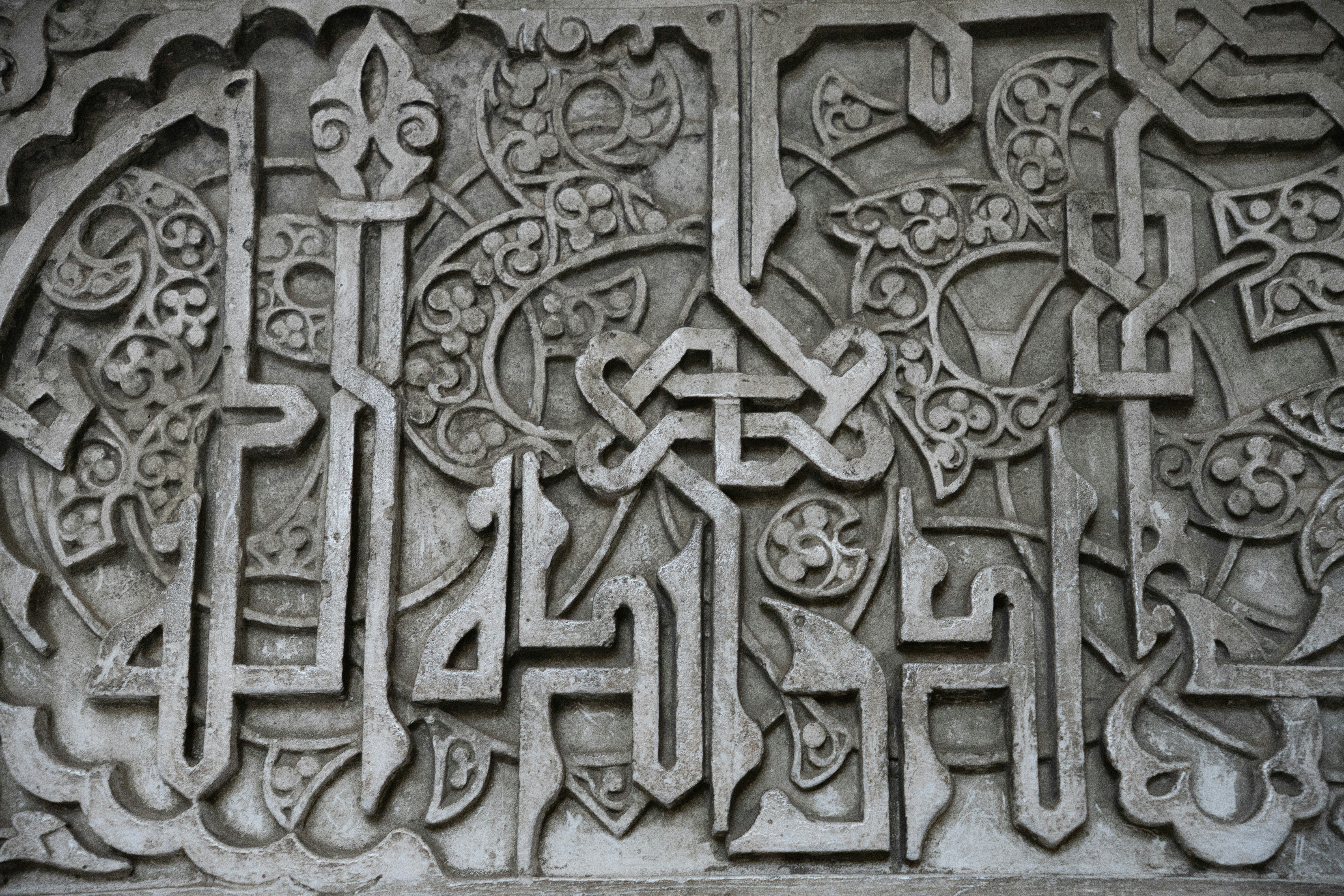 Intricate Carved Glyphs on Aged Stone Panel